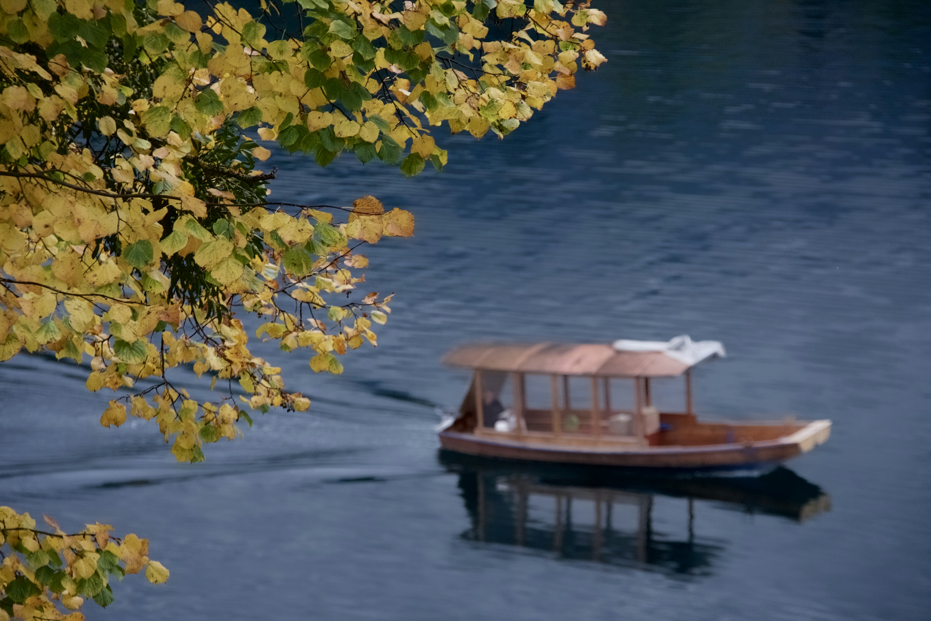 Autumn Vessel Drifts Across a Quiet Lake