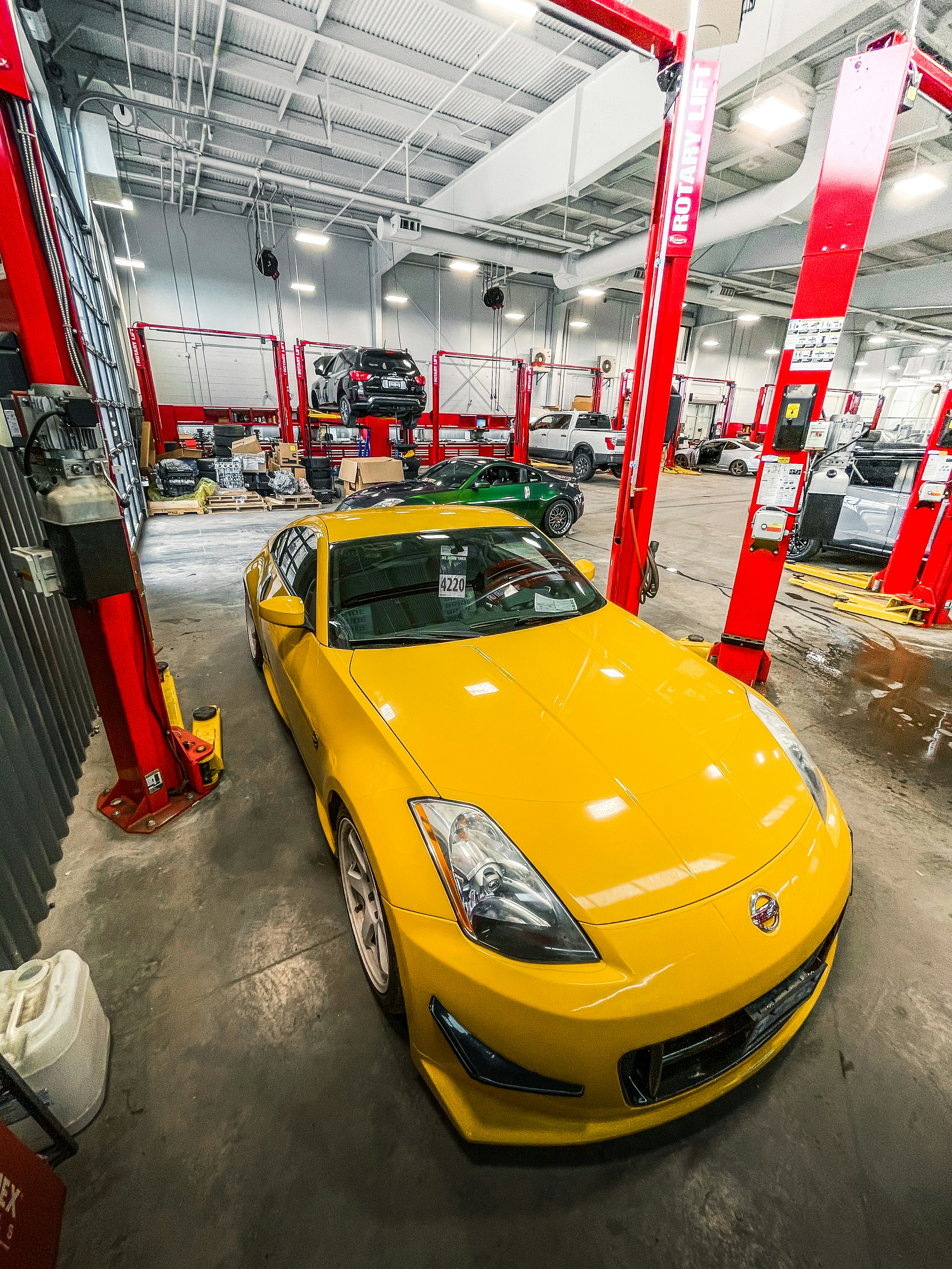 Yellow Corvette in a Busy Auto Shop Under Theme Park-like Lighting