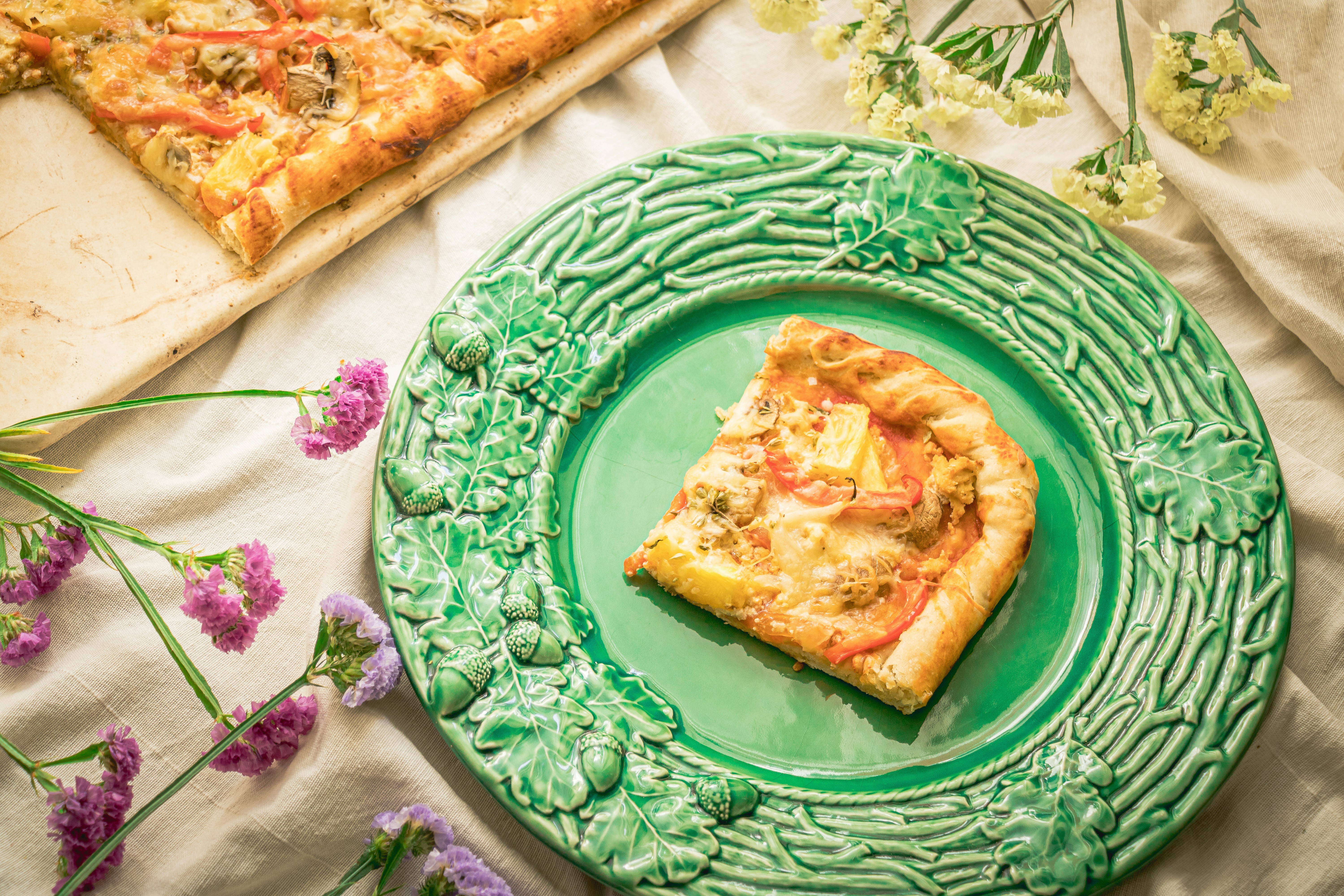 Green Plate, Greener Slice: A Pizza Moment Framed by Florals