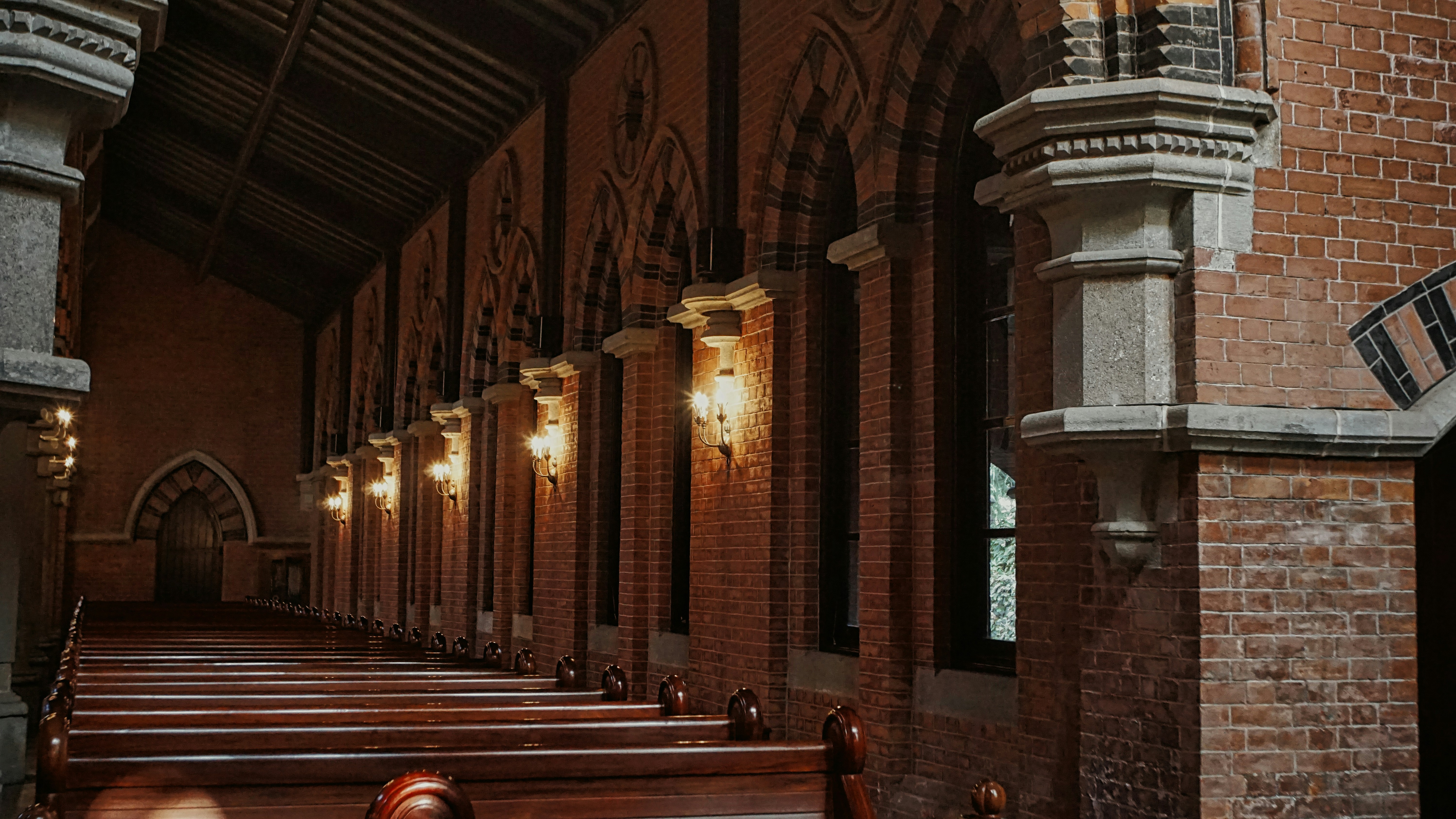 Brick Nave Illumination: Quiet Aisle Under Amber Lamps