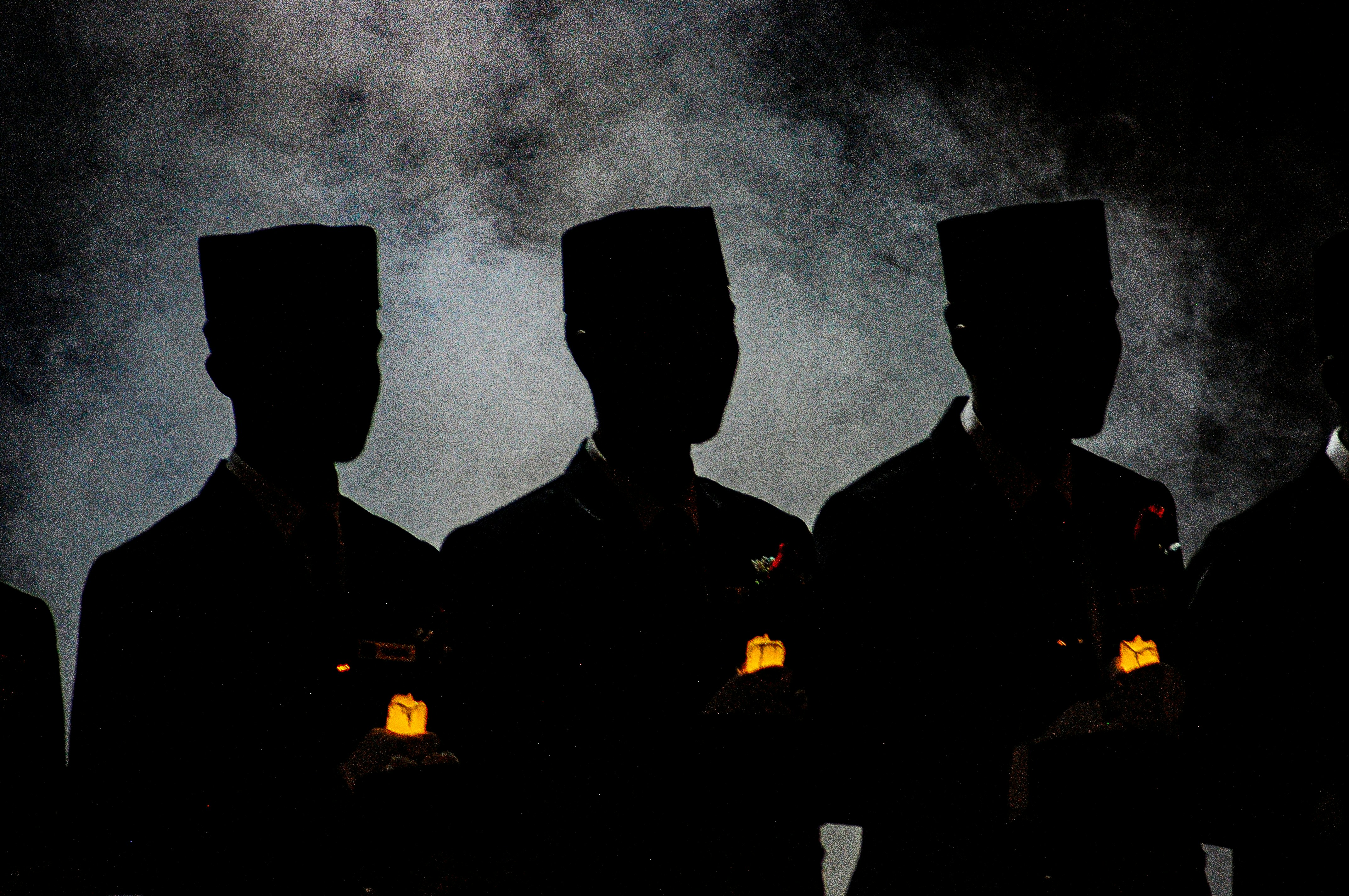 Silhouetted Cadets with Lanterns in a Misty Formations