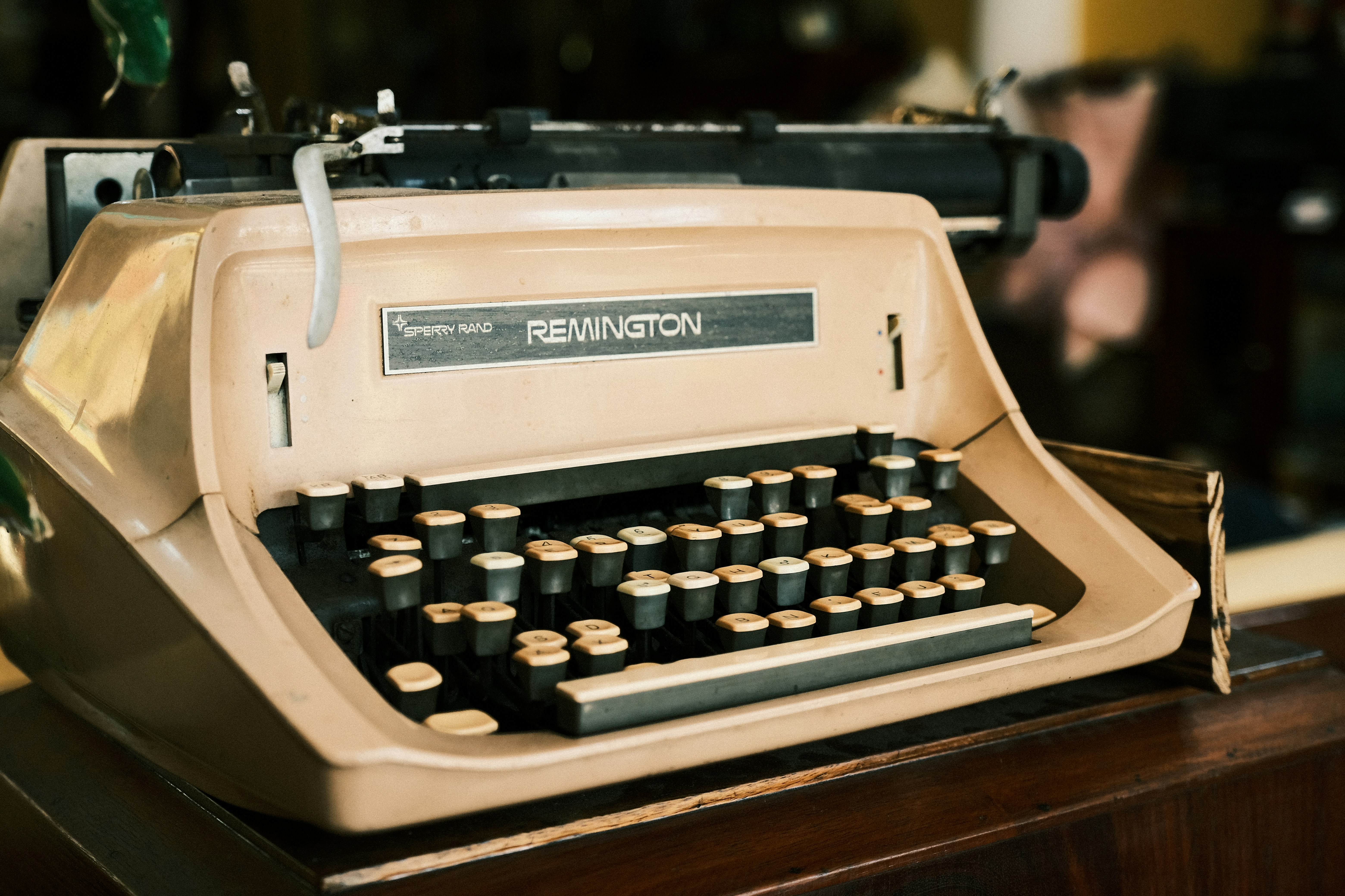 Classic Remington typewriter with worn keys, resting on a wooden desk.