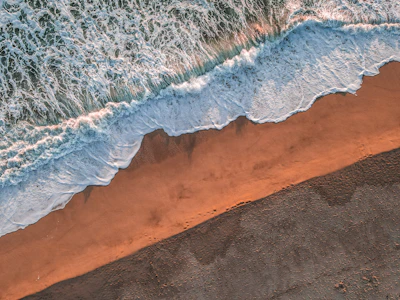 Foam Edge over Sunlit Sand: An Aerial Study of a Diagonal Shore