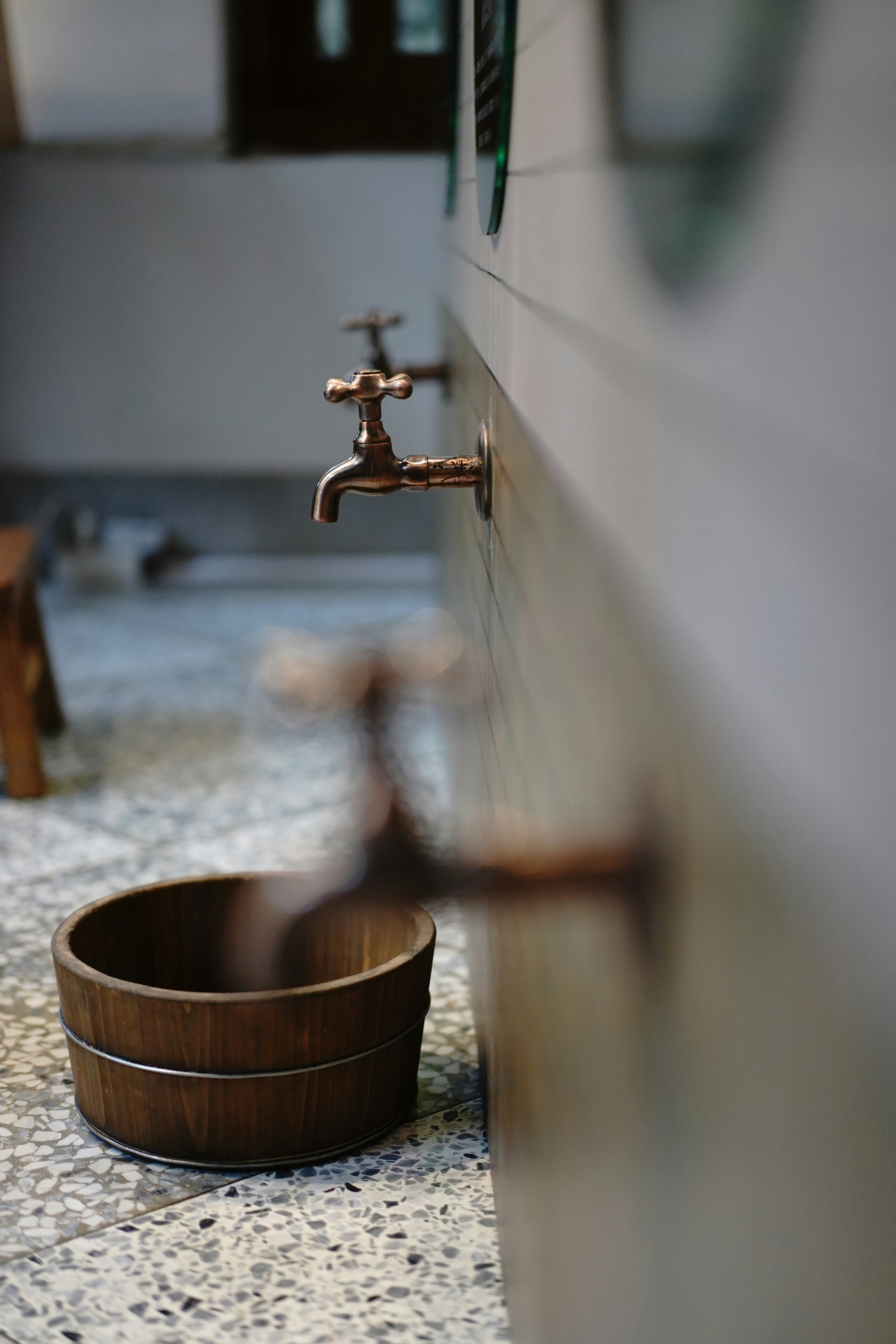 Copper Taps in Focus: A Quiet Row Along a Tiled Wall