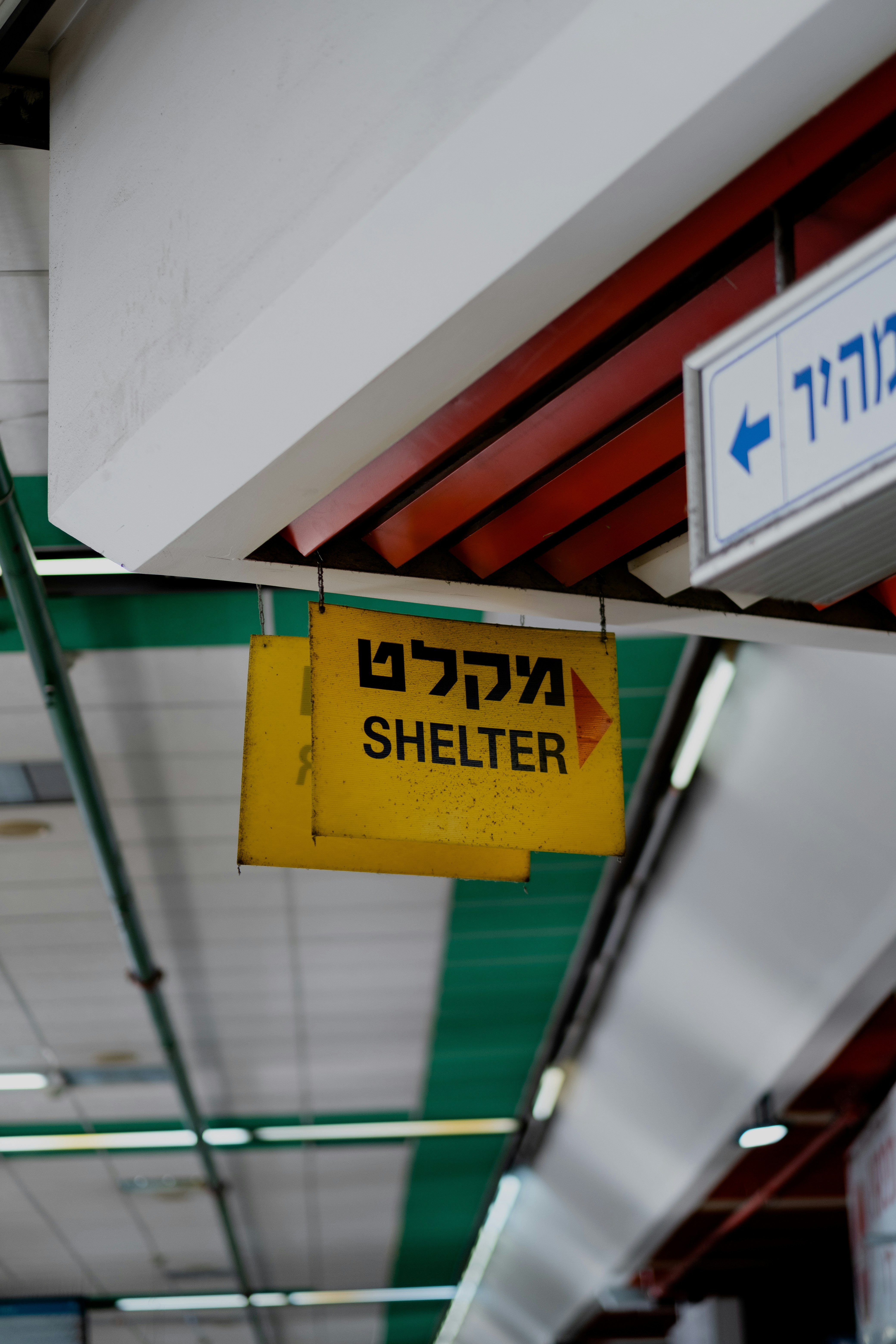 Directions to a bomb shelter at the central bus station in Tel Aviv. | yellow and black caution sign