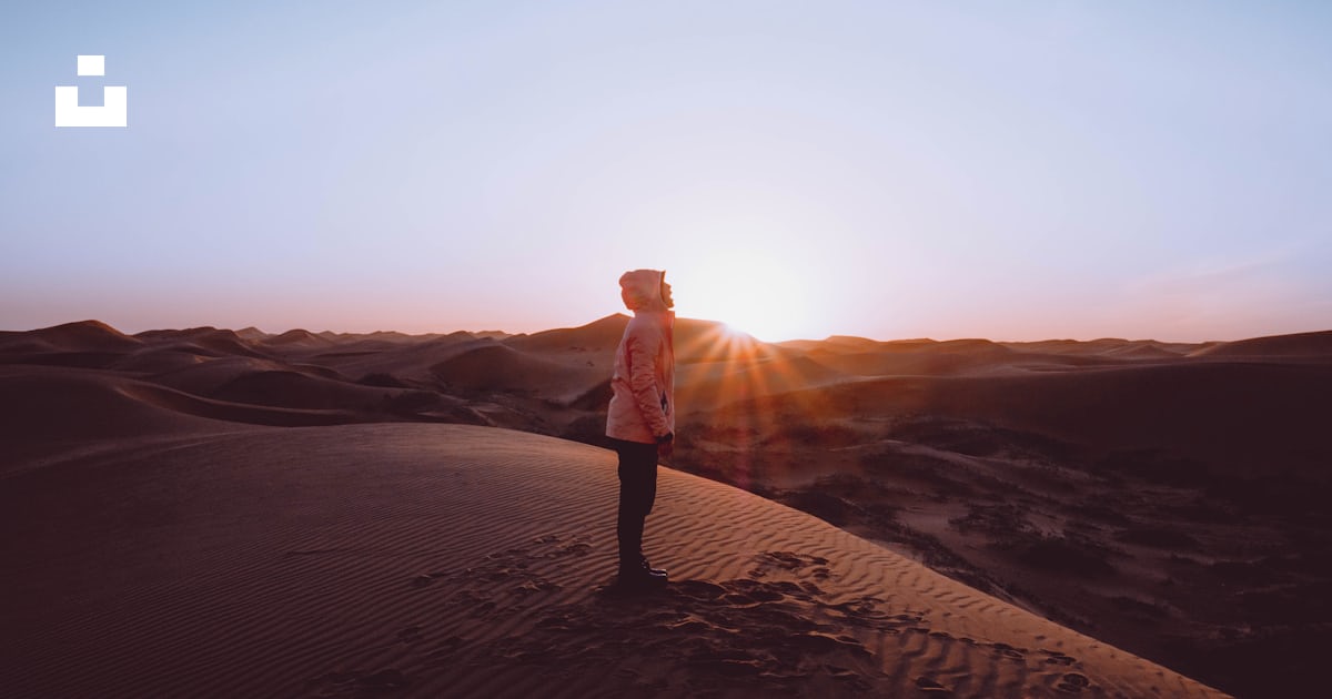 Man In Brown Jacket Standing On Brown Sand During Daytime Photo Free