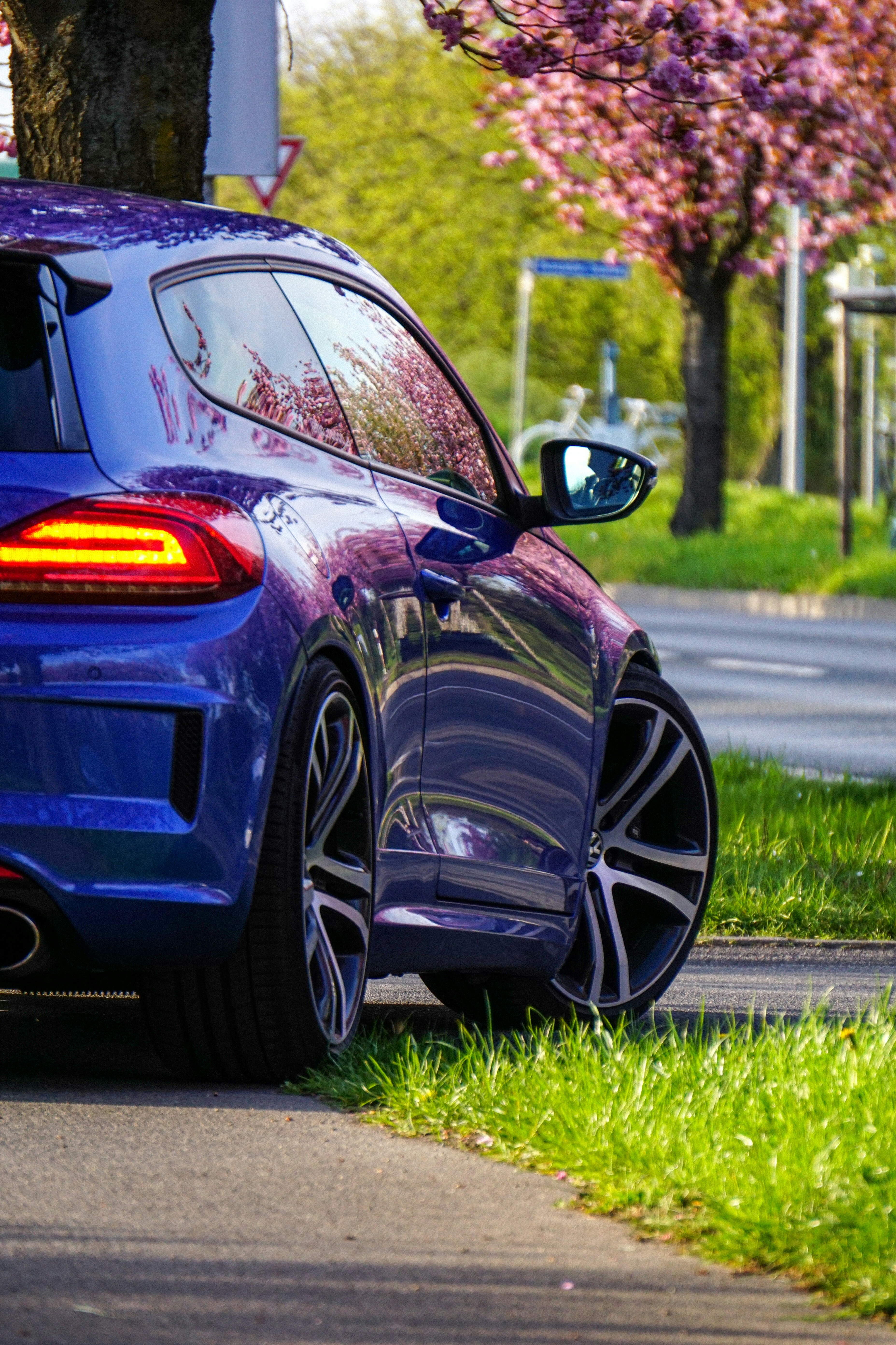 Blue Sports Car from the Rear Quarter with Blooming Spring Trees