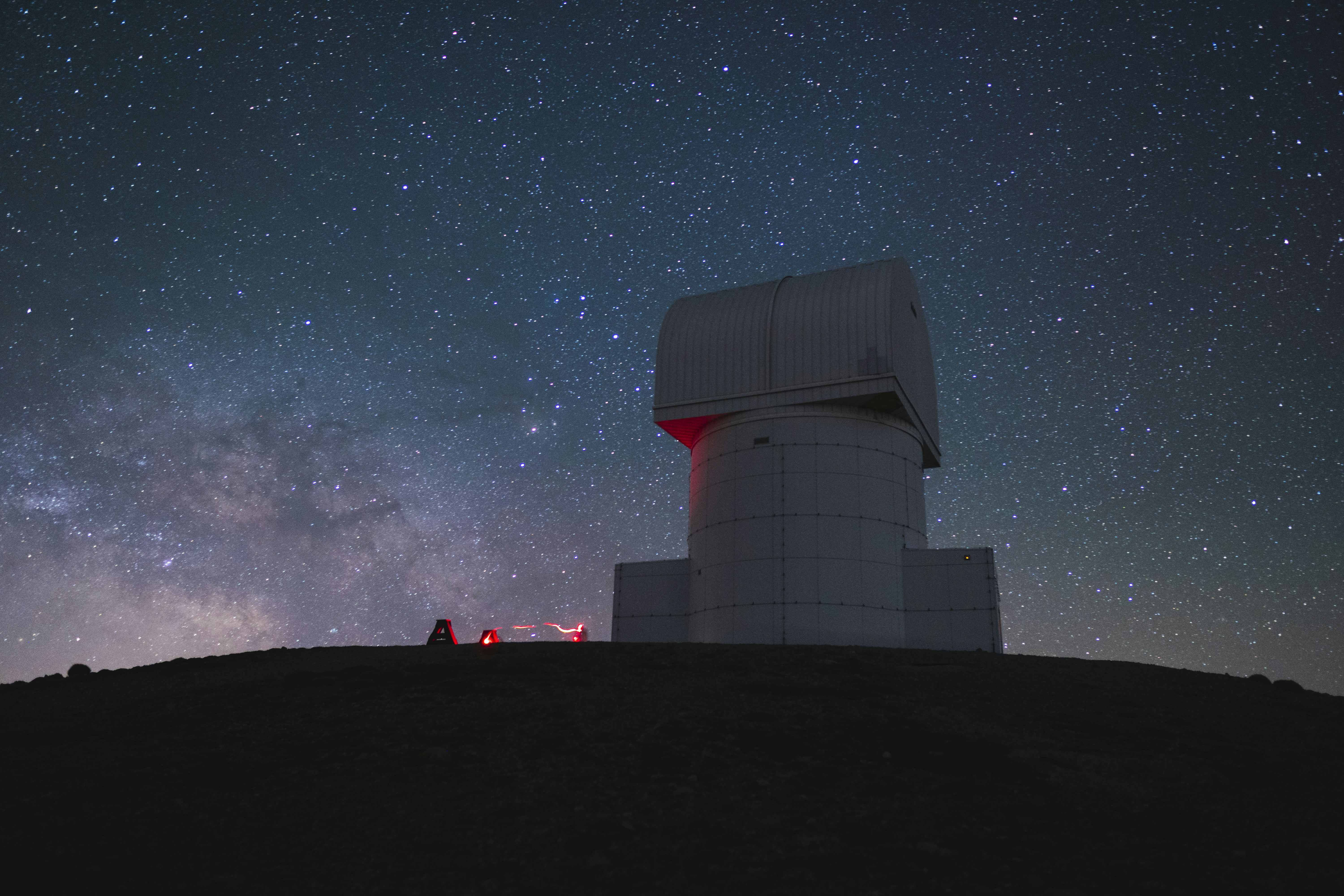 Silhouette of an observatory beneath a star-filled sky and the Milky Way.