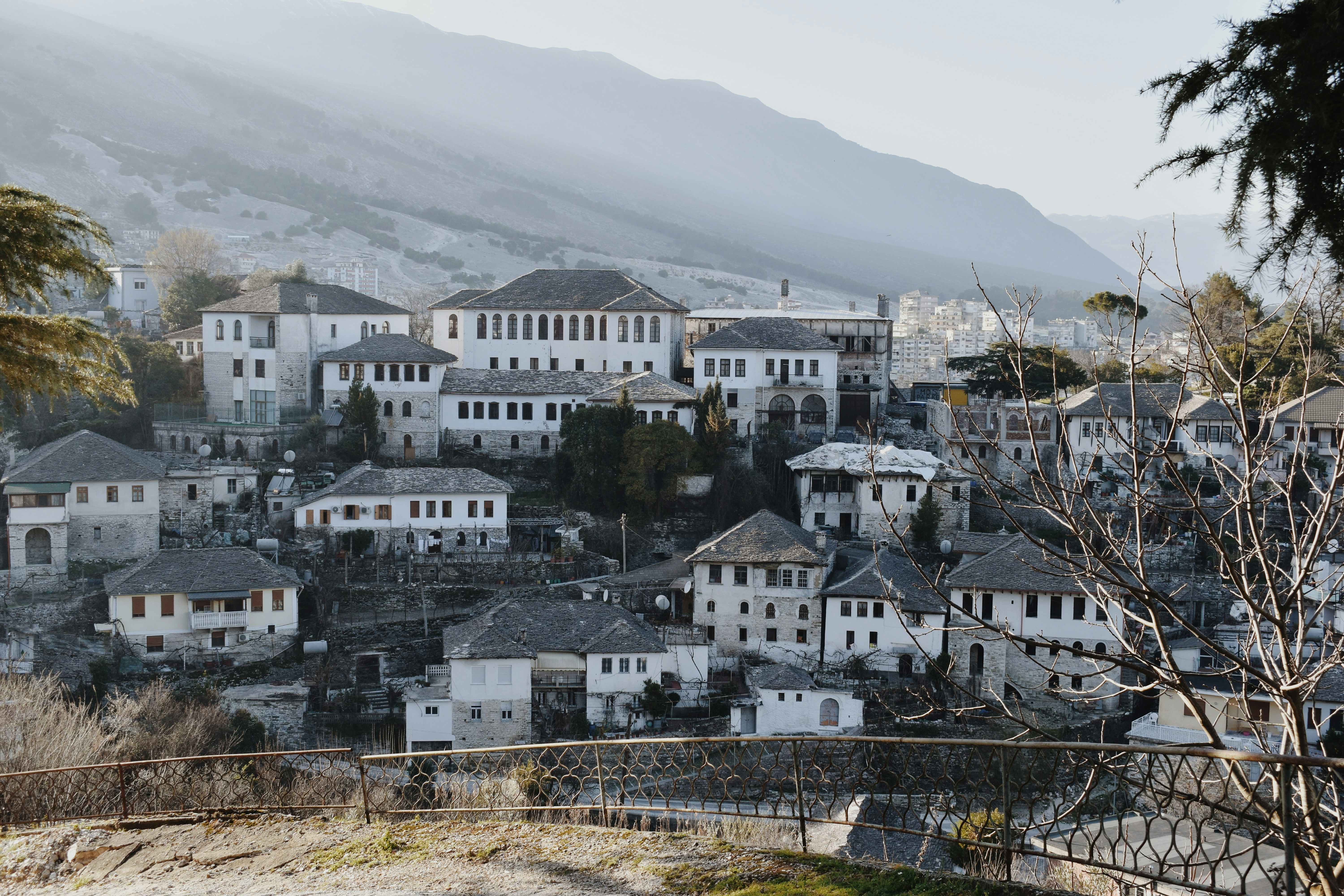 Historic village nestled among mountains, showcasing traditional architecture and a serene atmosphere. The interplay of light and shadow adds depth to the scene.
