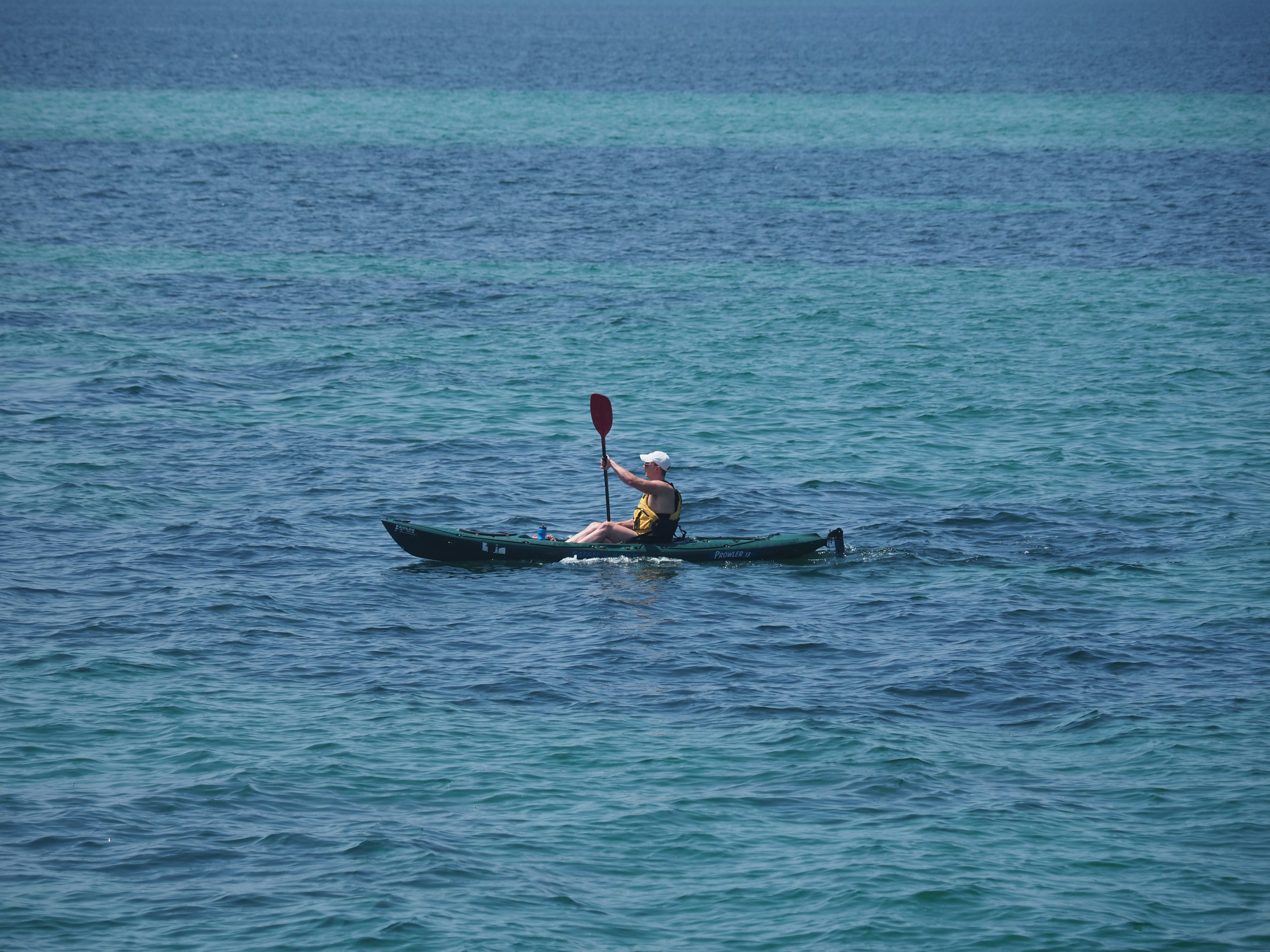 Man in red shirt riding on black kayak on blue sea during daytime photo ...