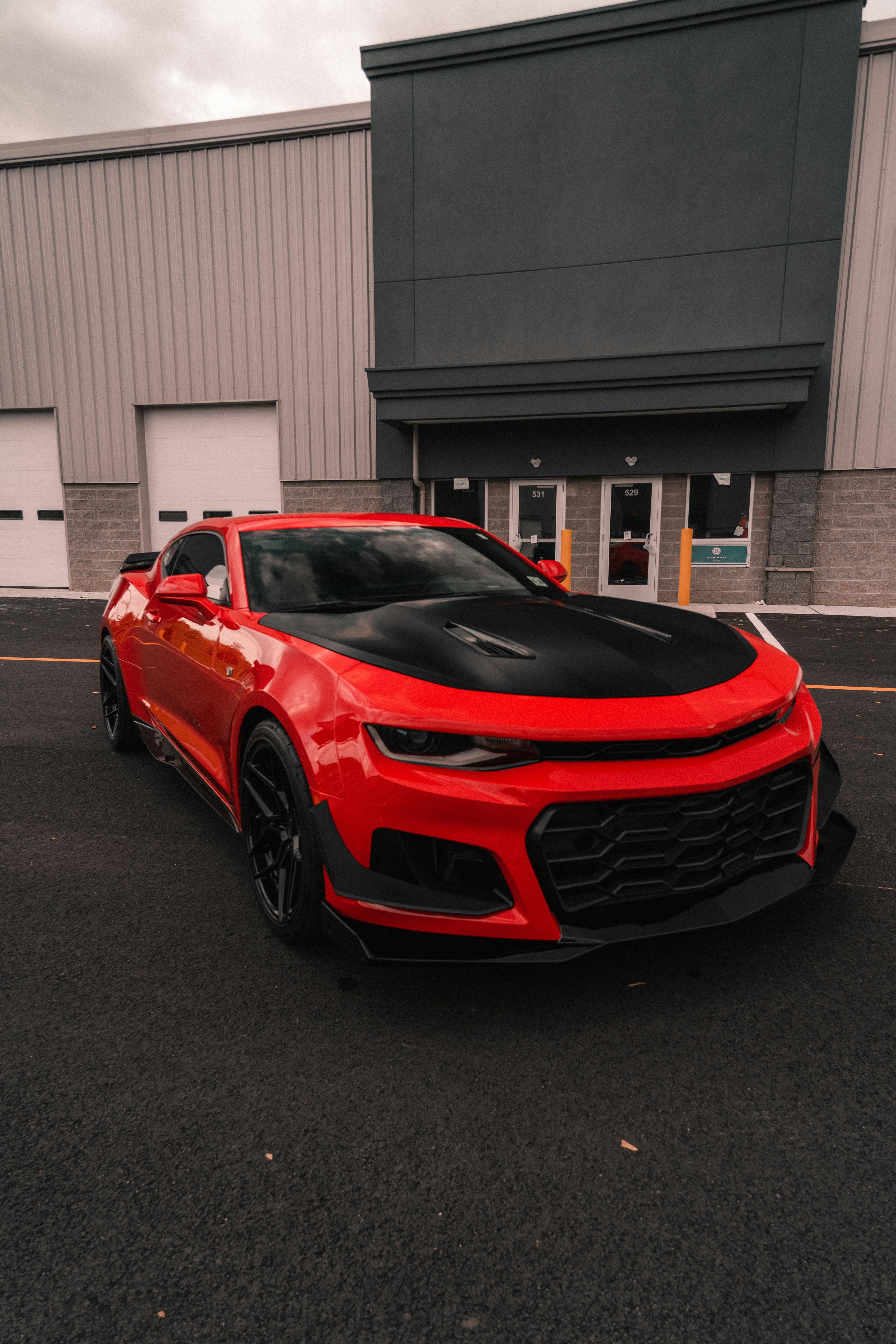 Chevrolet Camaro rouge garée devant un bâtiment blanc photo – Photo ...