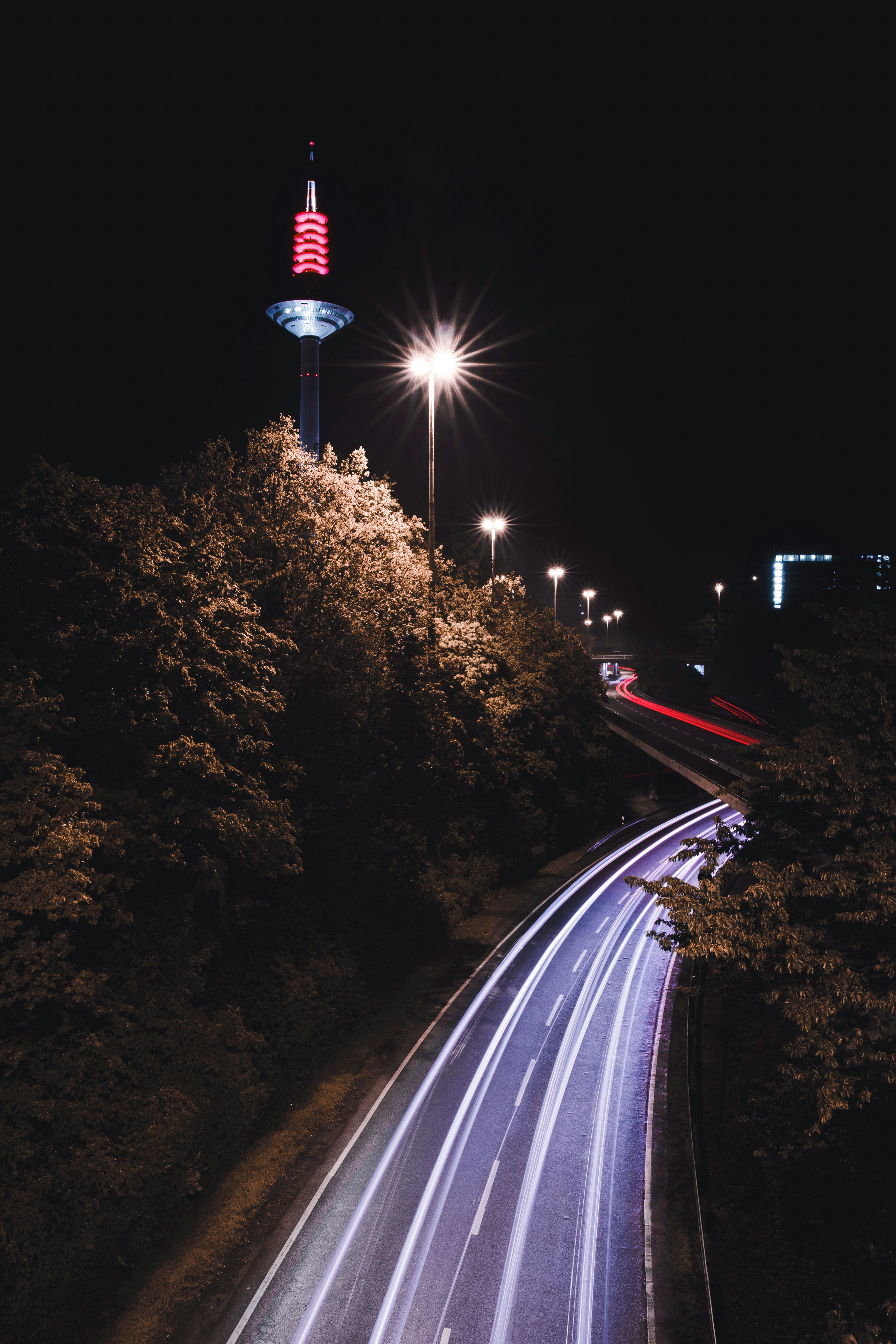 Crimson Spire and Silver Trails: Night Corridor Under City Lights