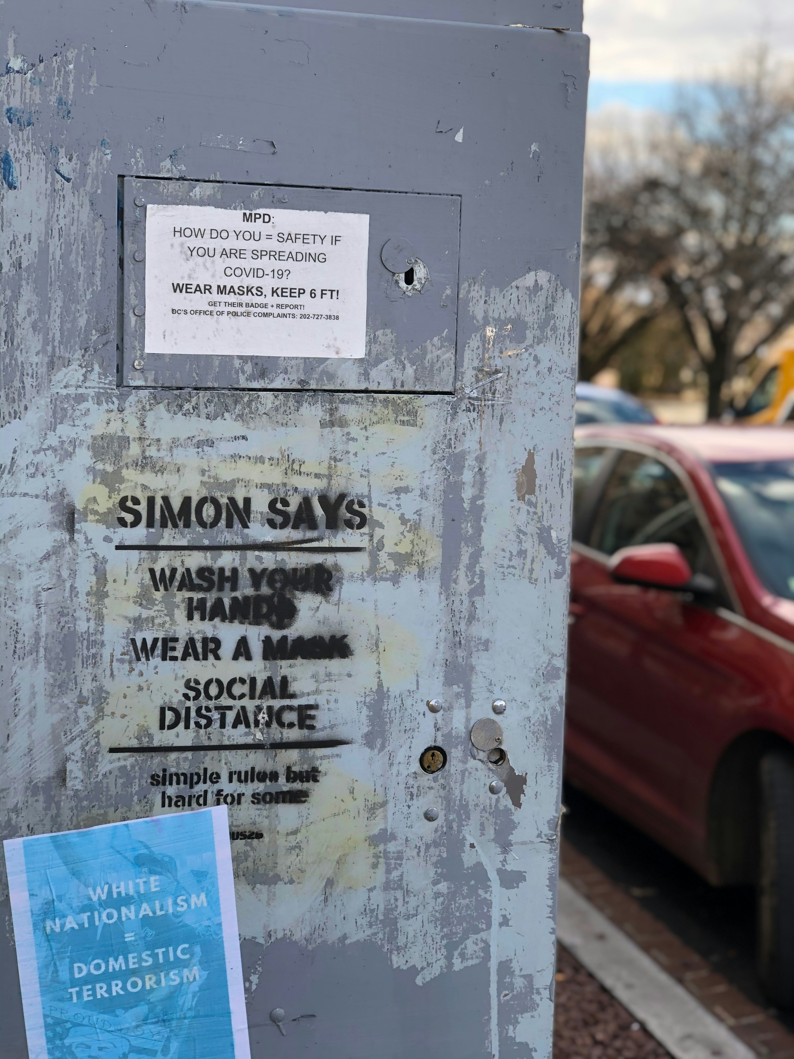 Sign of the times. Public service announcements via handbills on the corner. | white and black signage on gray wooden post