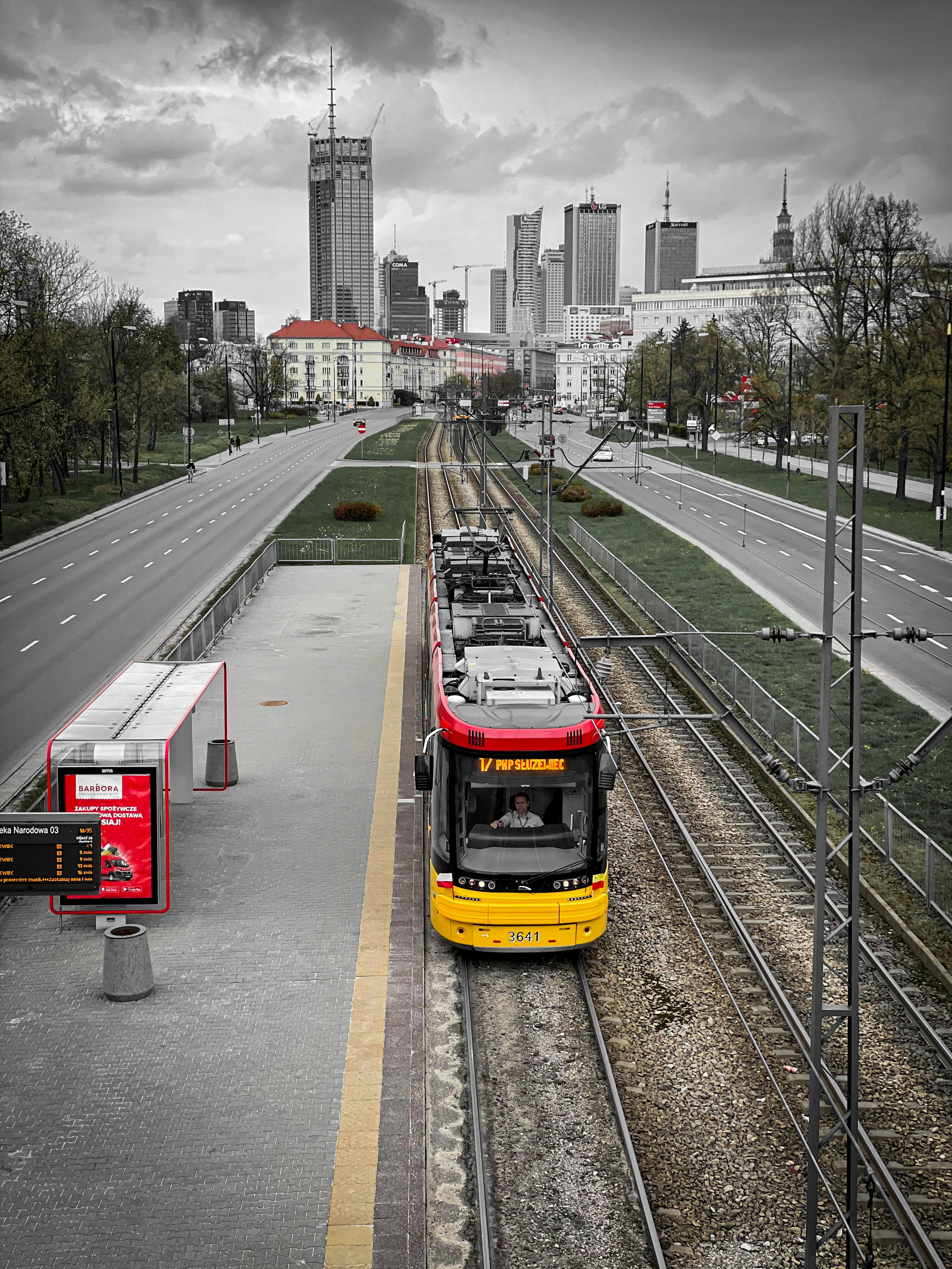 Railway Pulse: A yellow tram threading through city rails toward a distant skyline