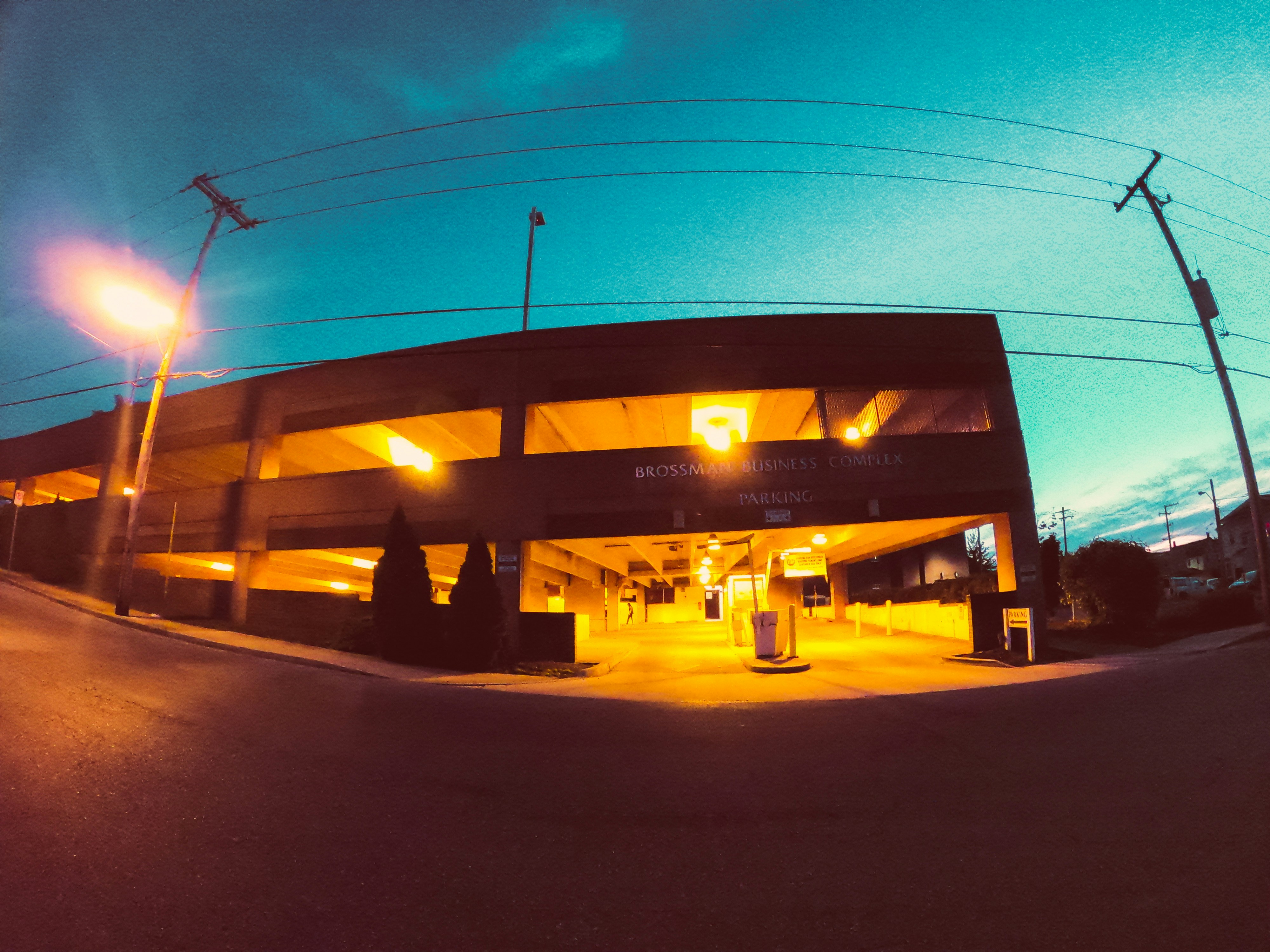 Dusk Under the Curved Canopy: Warm Light Spill from a Parking Garage