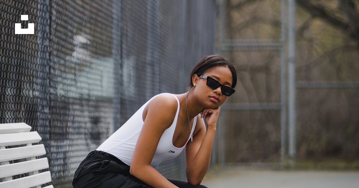 Foto Mujer Con Camiseta Blanca Y Pantalón Negro Sentada En Un Banco