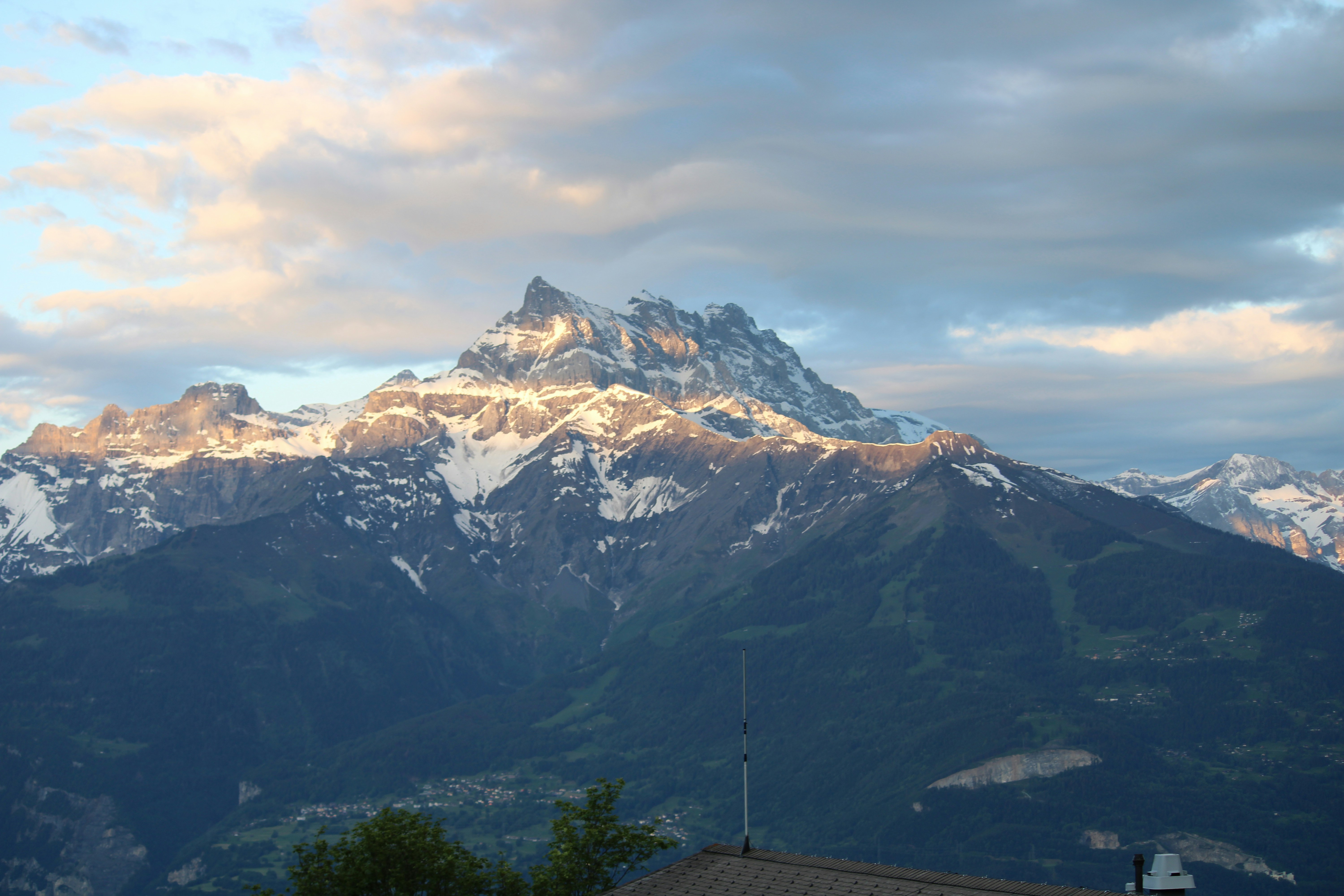 Snow-Crowned Peak Illuminated Over a Green Alpine Valley