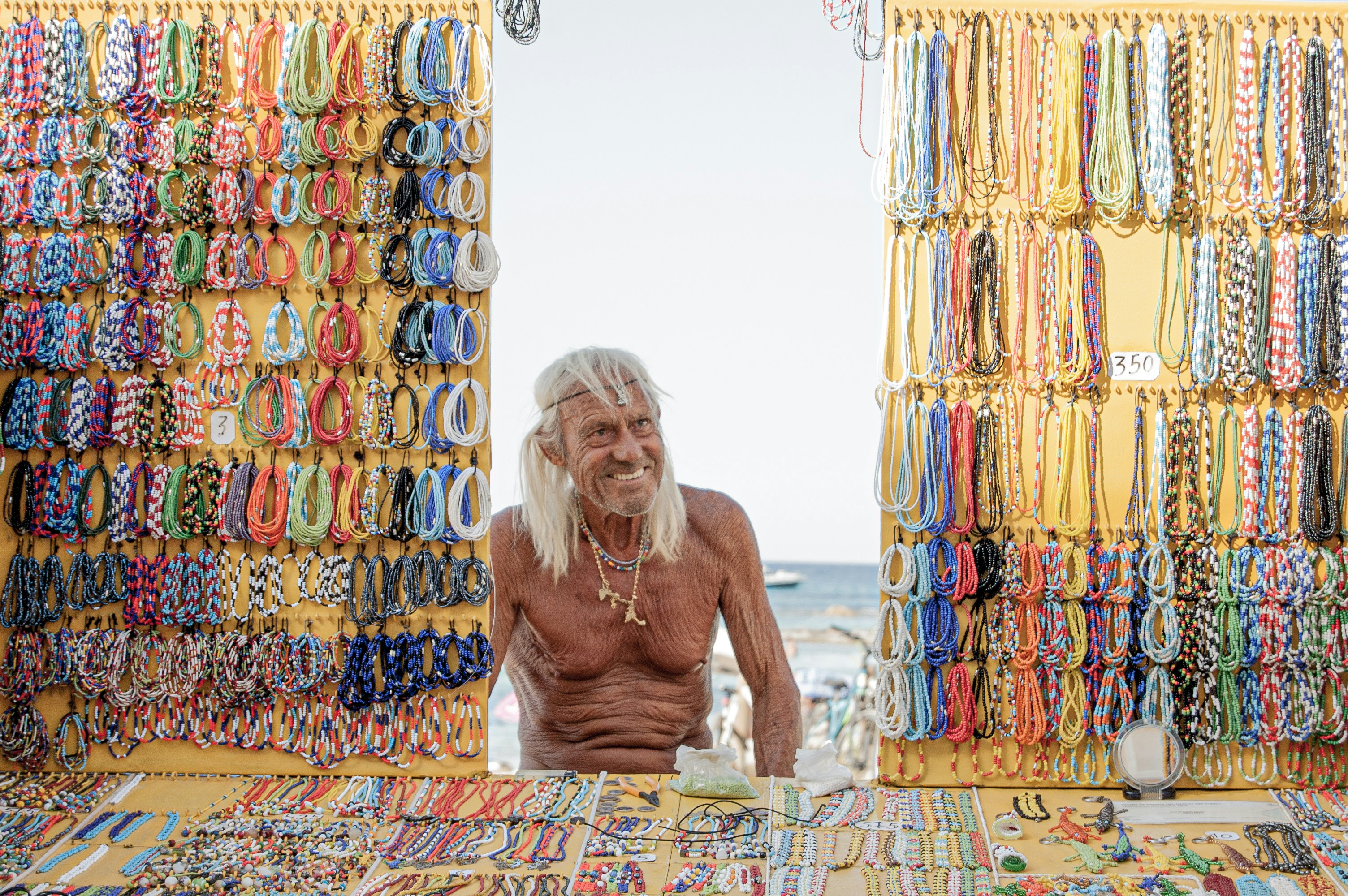 Bright Vendor of Beads: A Sunlit Corner by the Beach