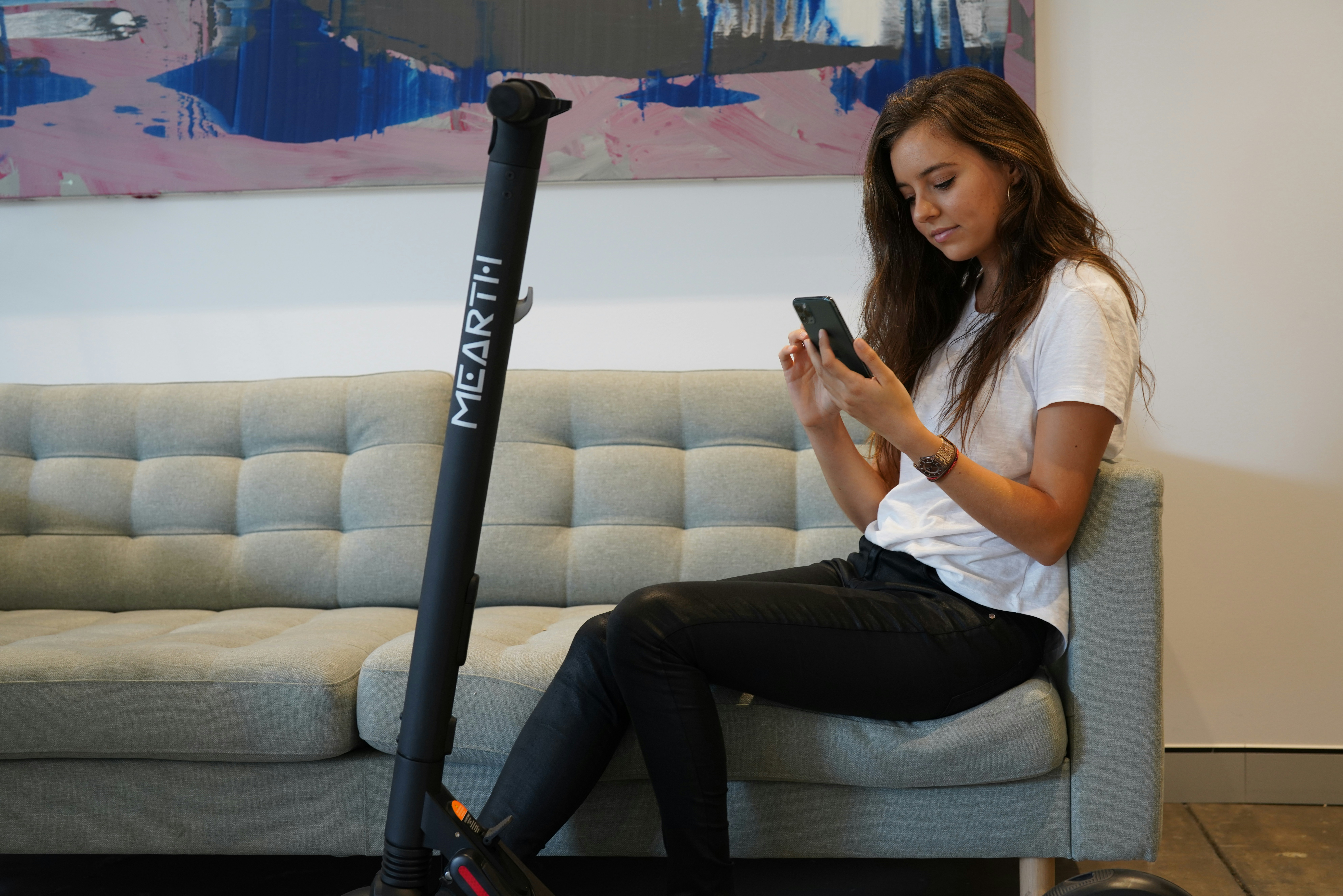 Casual tech moment: a woman with a smartphone on a modern sofa