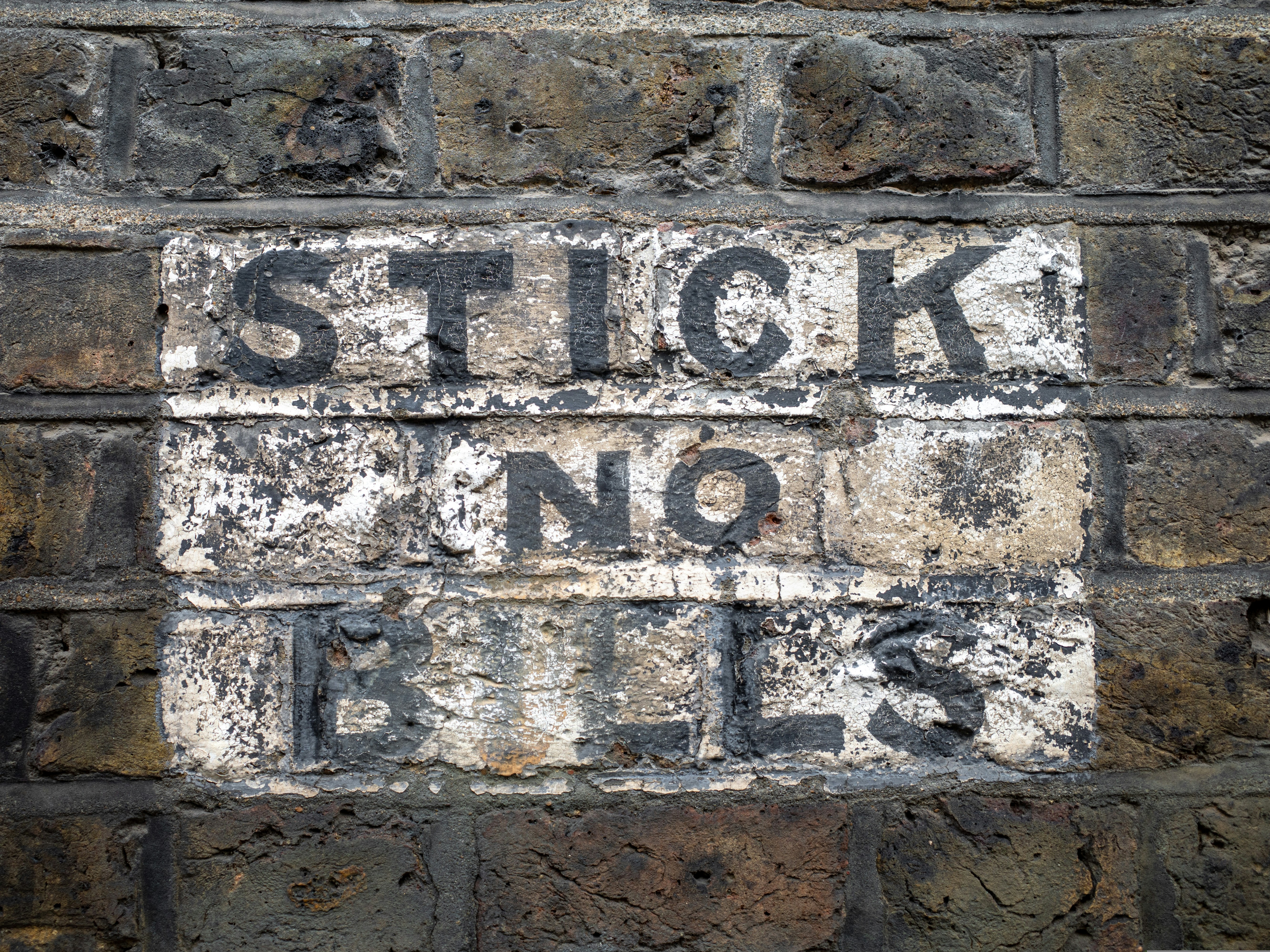A brick wall with a sign that says stick no rules photo – Free Grey ...