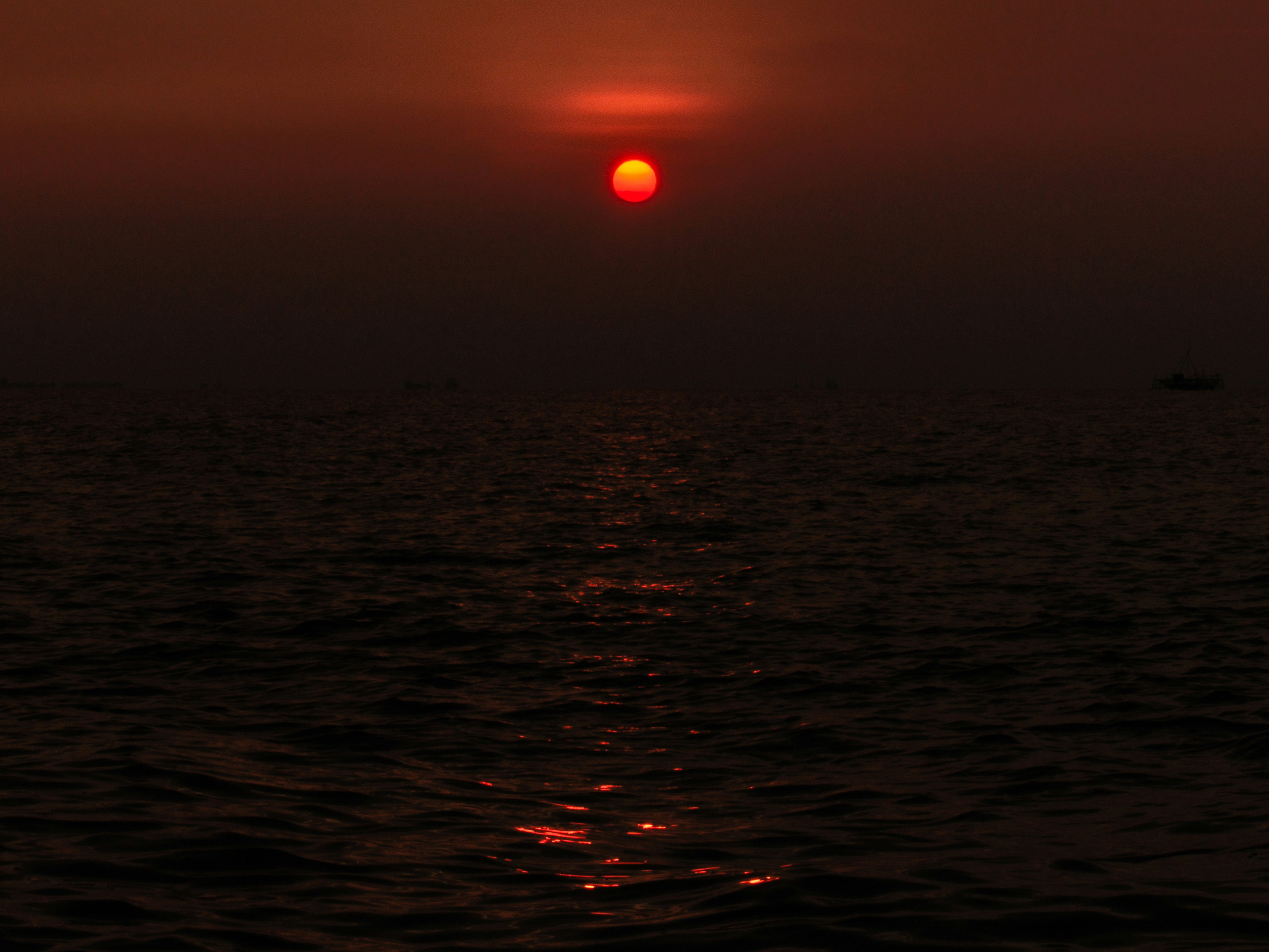 Crimson Orb at Dusk: The Sea's Quiet Reflection