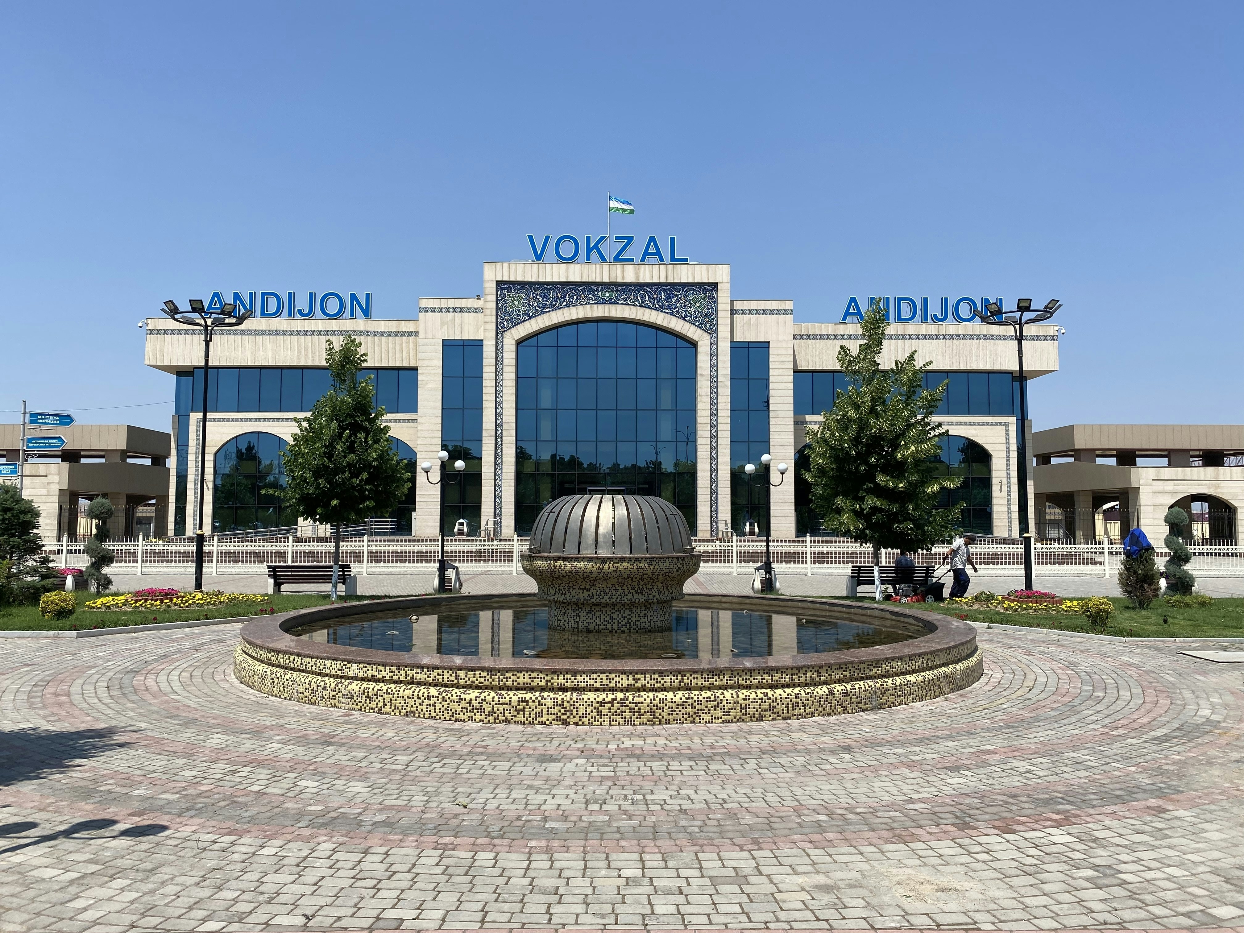 Architectural marvel of Andijon railway station featuring a central fountain and landscaped gardens.