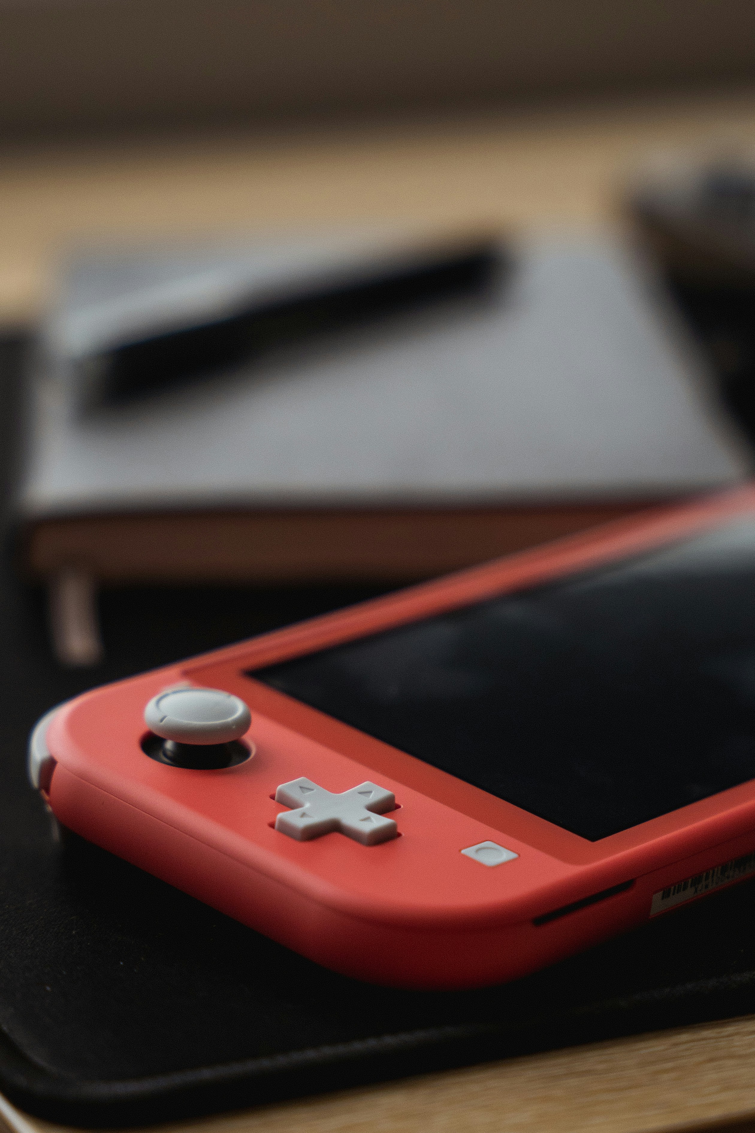 Red nintendo switch on brown wooden table photo – Free Pink Image on ...