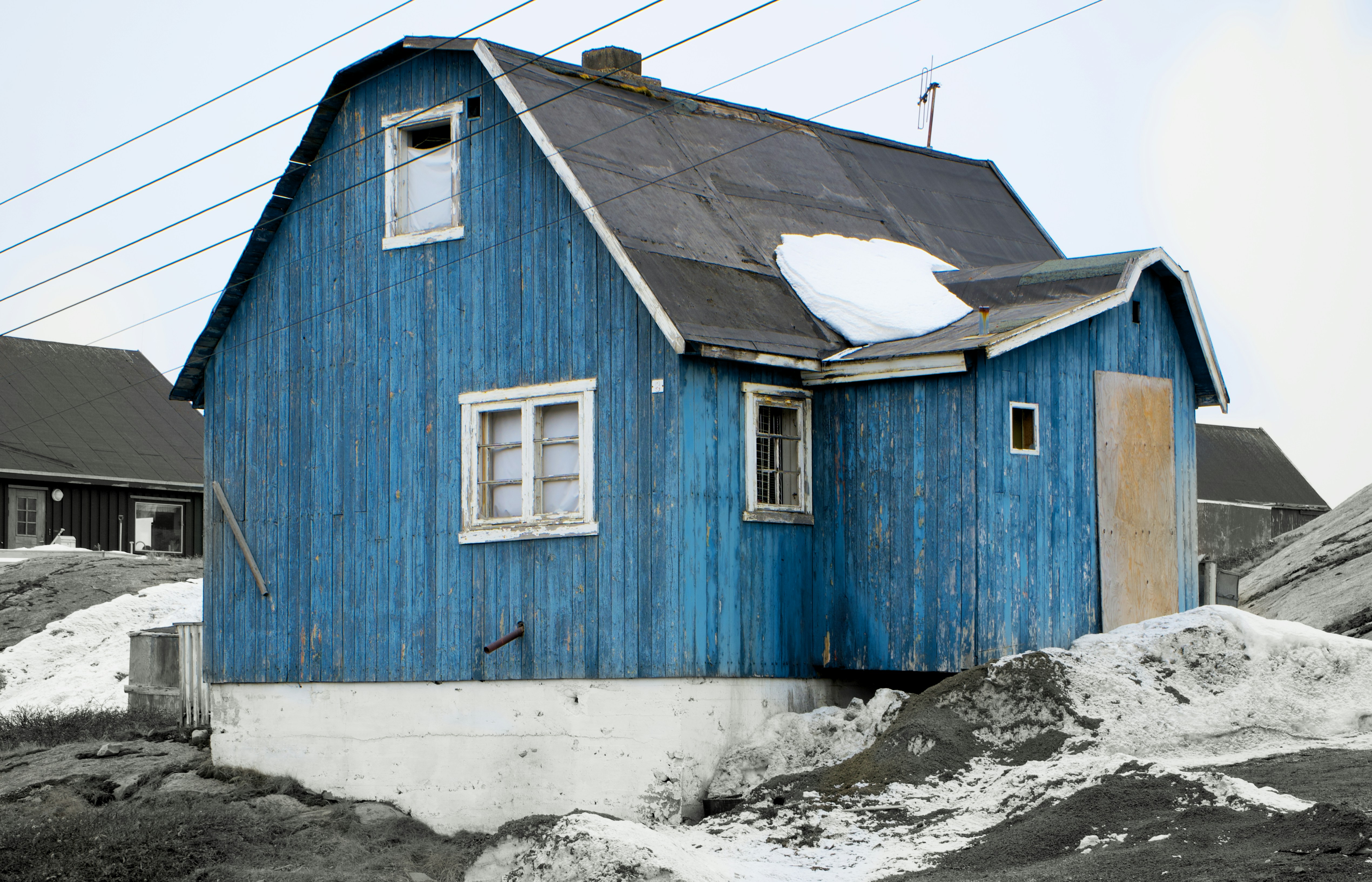 blue and white wooden house on white snow covered ground during daytime