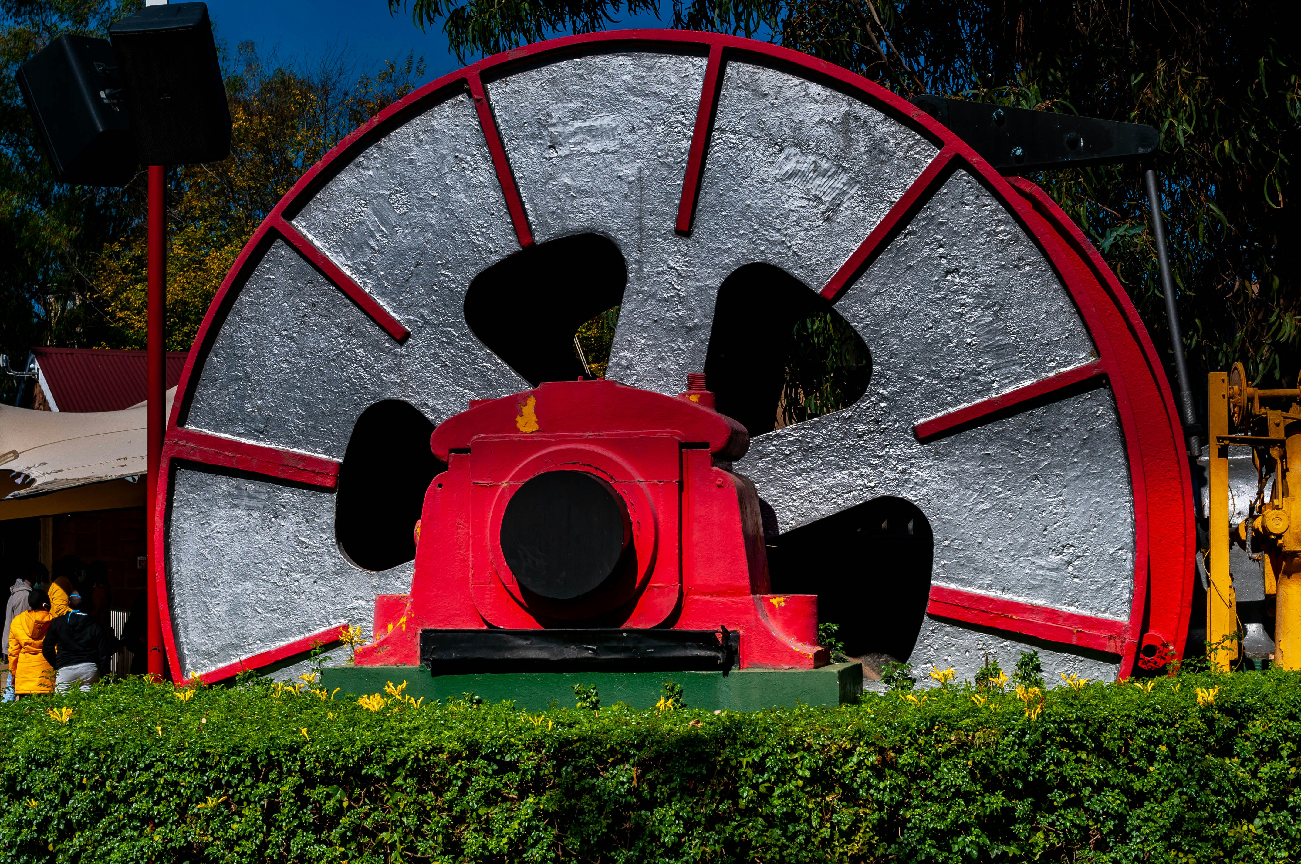 Red reel of motion: a giant vintage cinema wheel framing a bold red mechanism