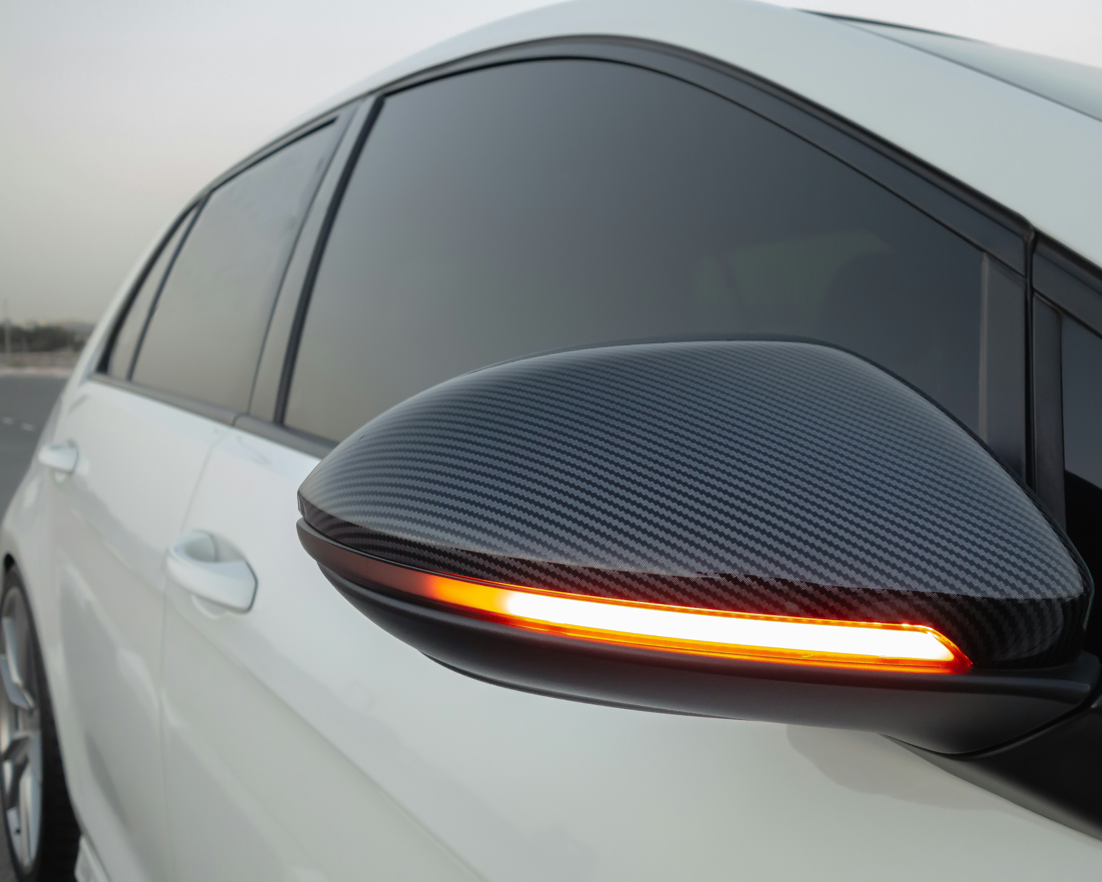 Carbon-Fiber Side Mirror with Orange LED Stripe on a White SUV
