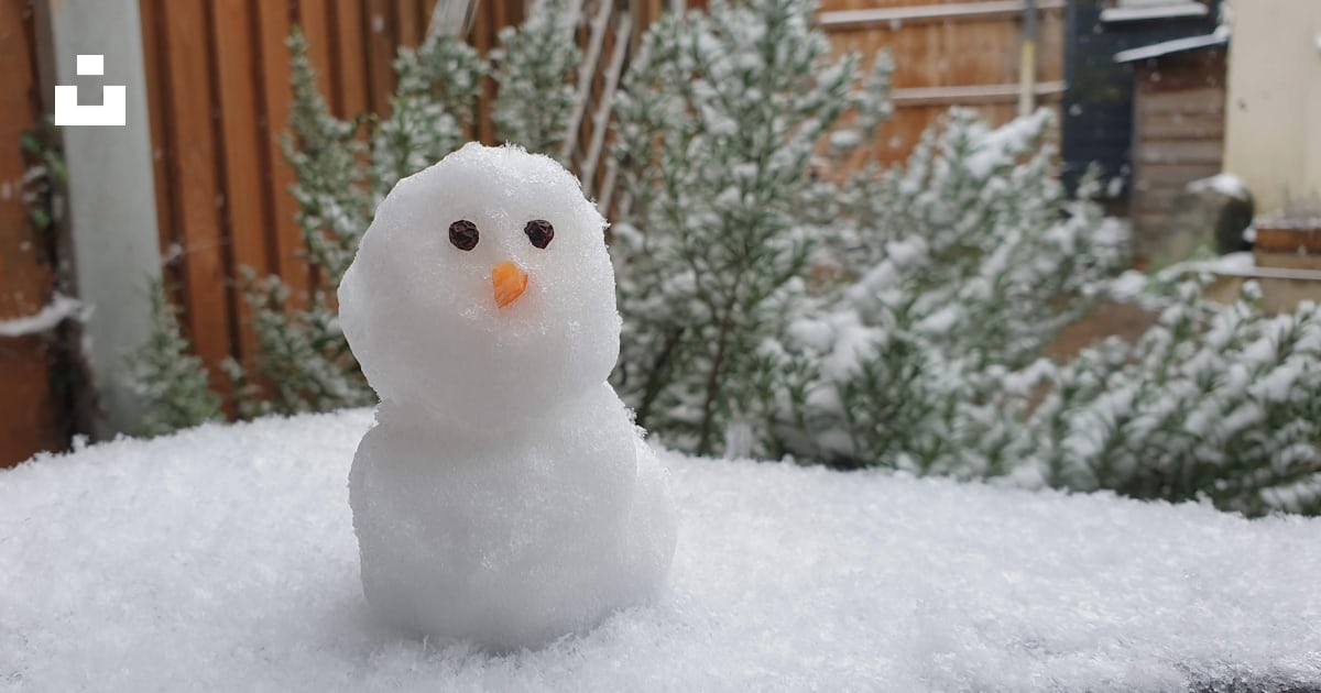 昼間の雪に覆われた地面に白い雪だるまの写真 Unsplashの無料雪写真