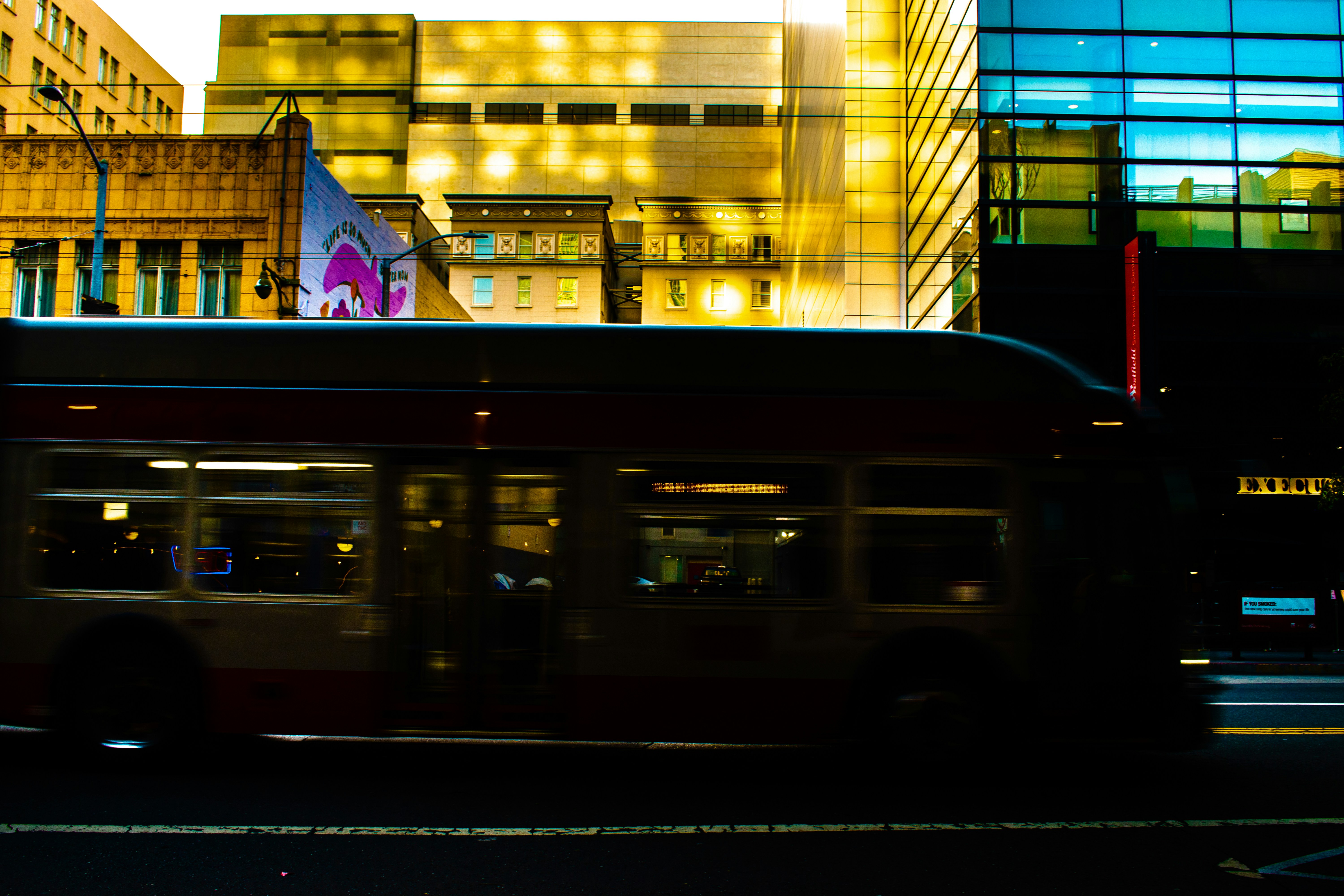 Rush Hour in Neon Echoes: Bus Blurs Through Golden Cityscape