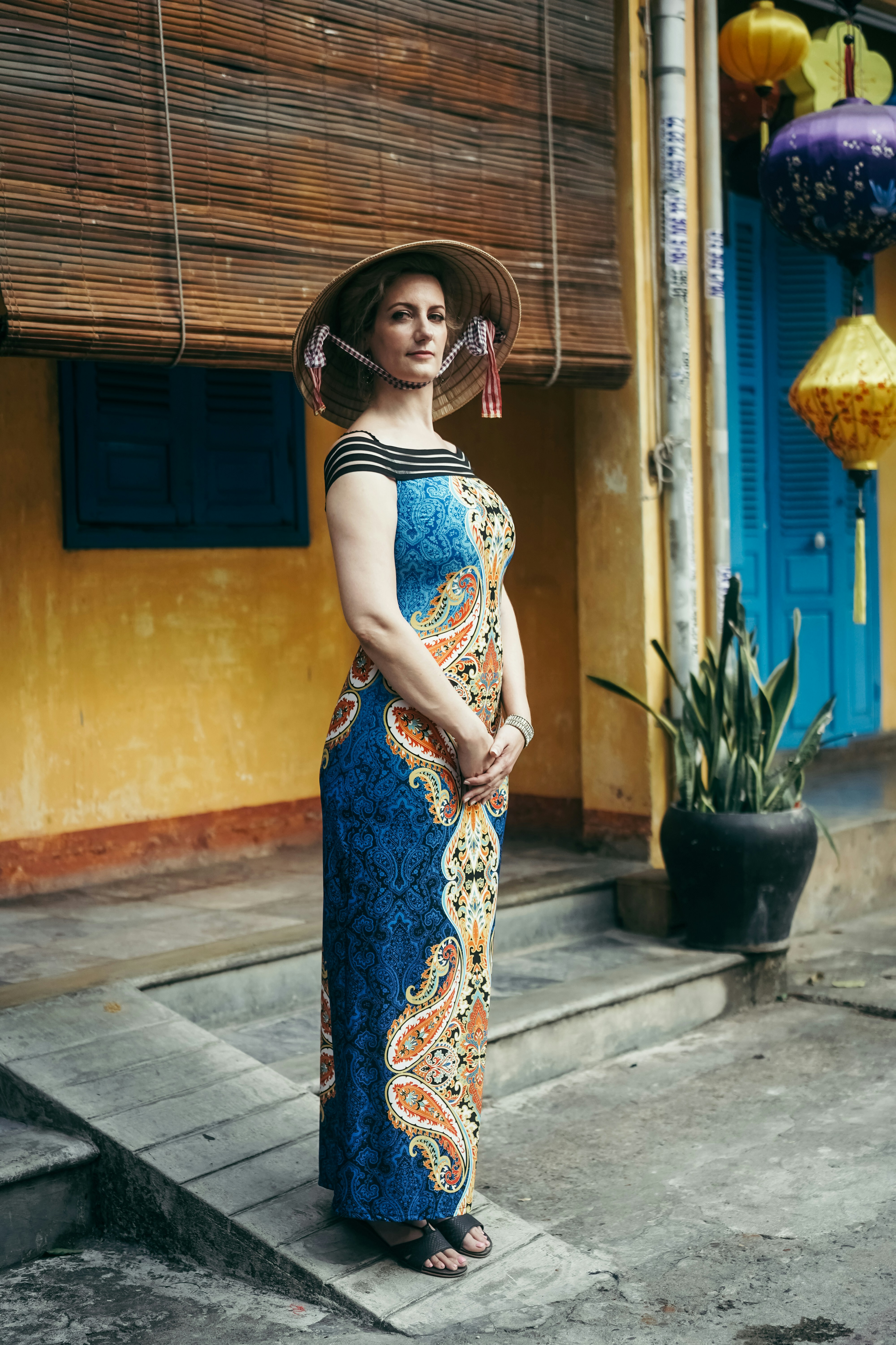 Woman in blue and brown floral sleeveless dress standing on gray ...