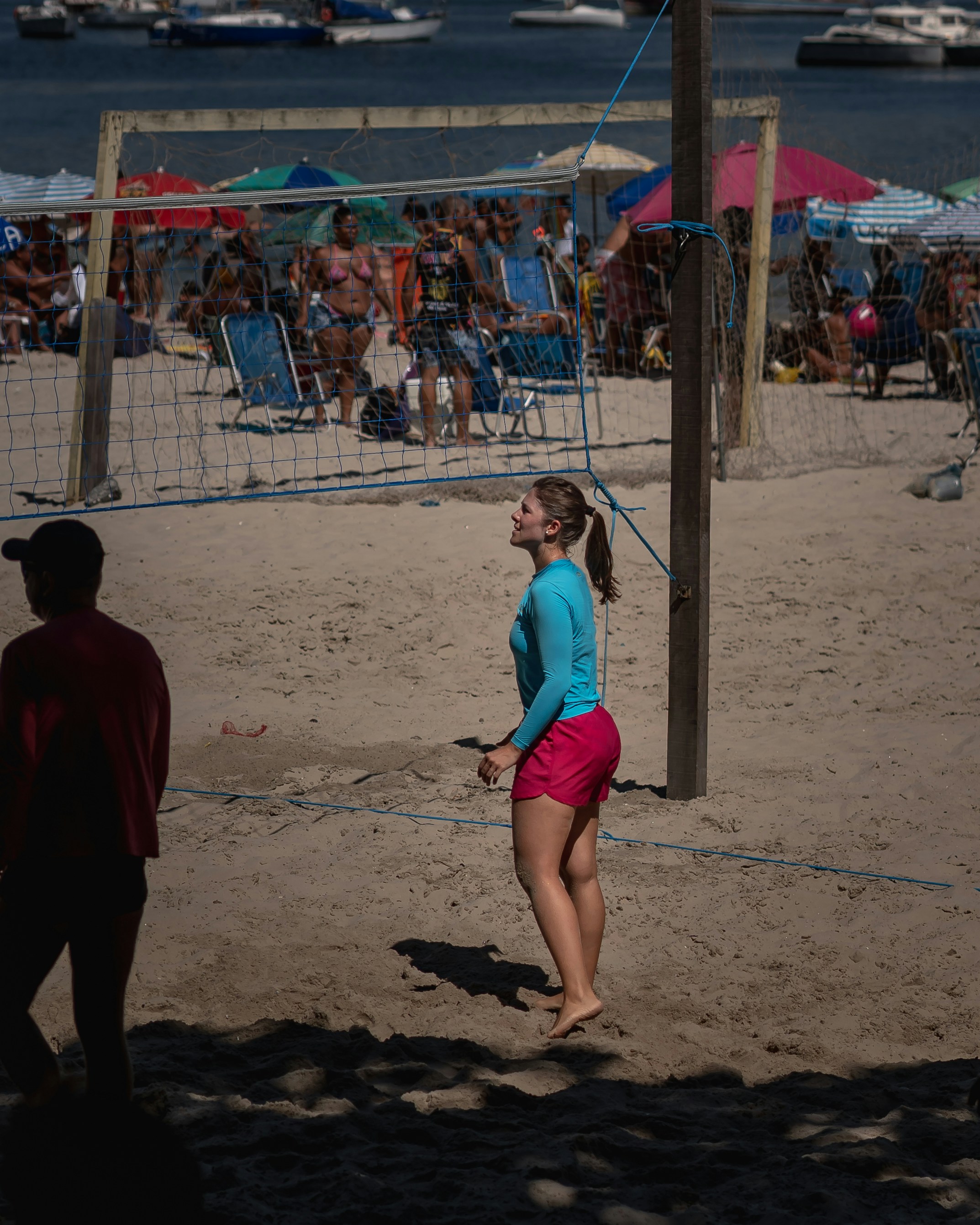 Turquoise Top, Pink Shorts: A Solo Player Anchors a Sun-Baked Beach Volleyball Scene