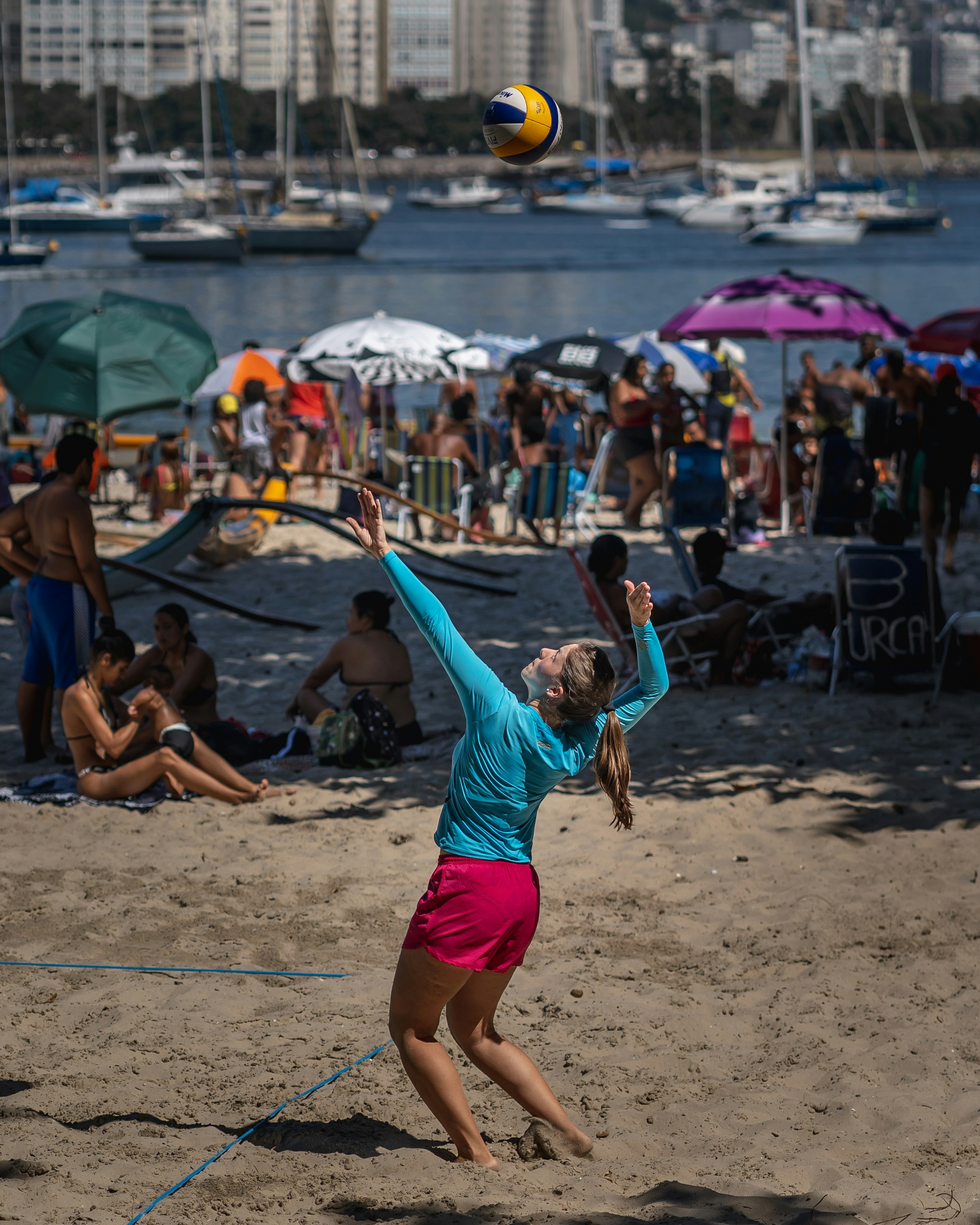 Liftoff on the Beach: A Volleyball Dive Under a Sunlit Crowd