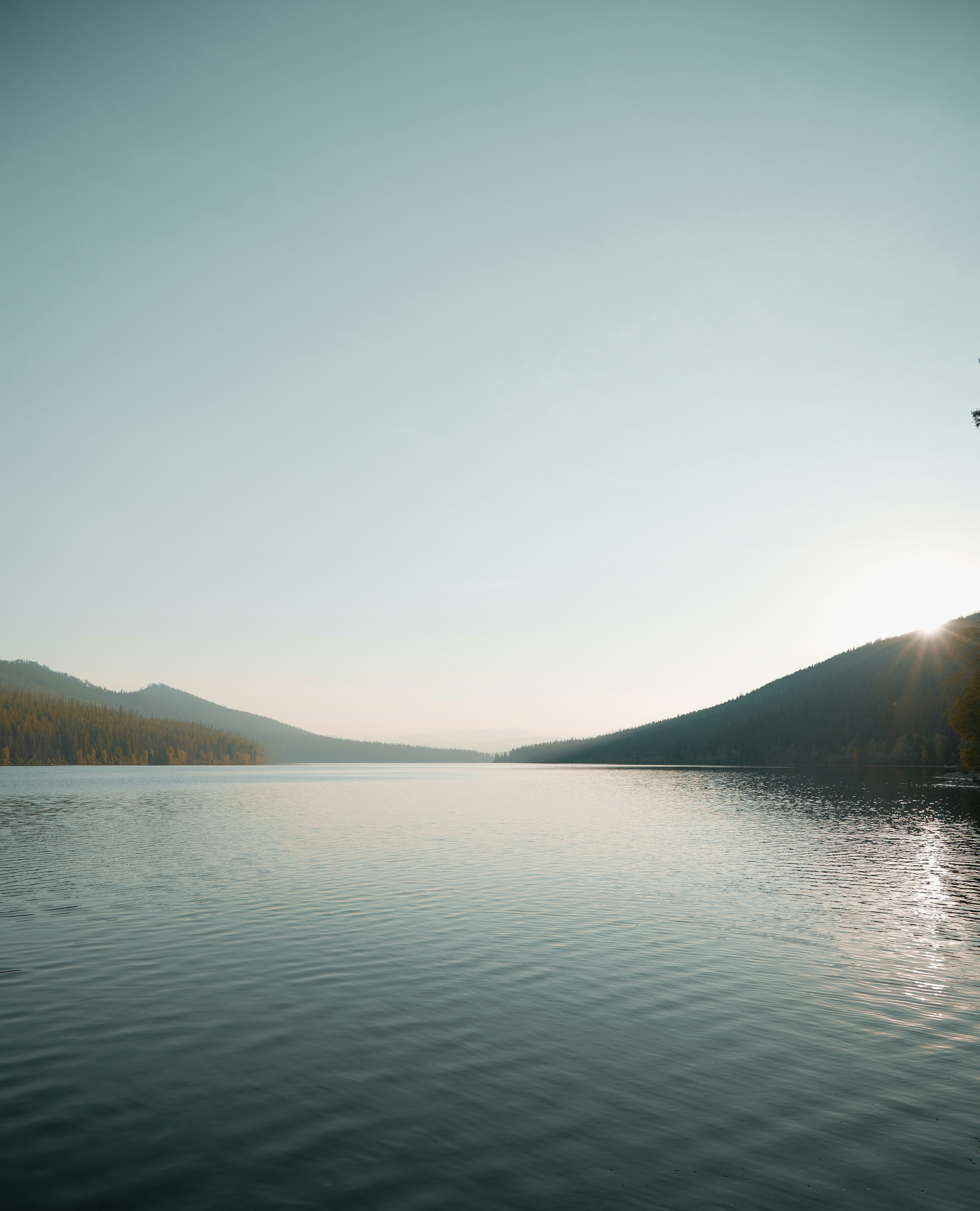 Calm Sunset on a lake in Glacier National Park | body of water near mountain during daytime