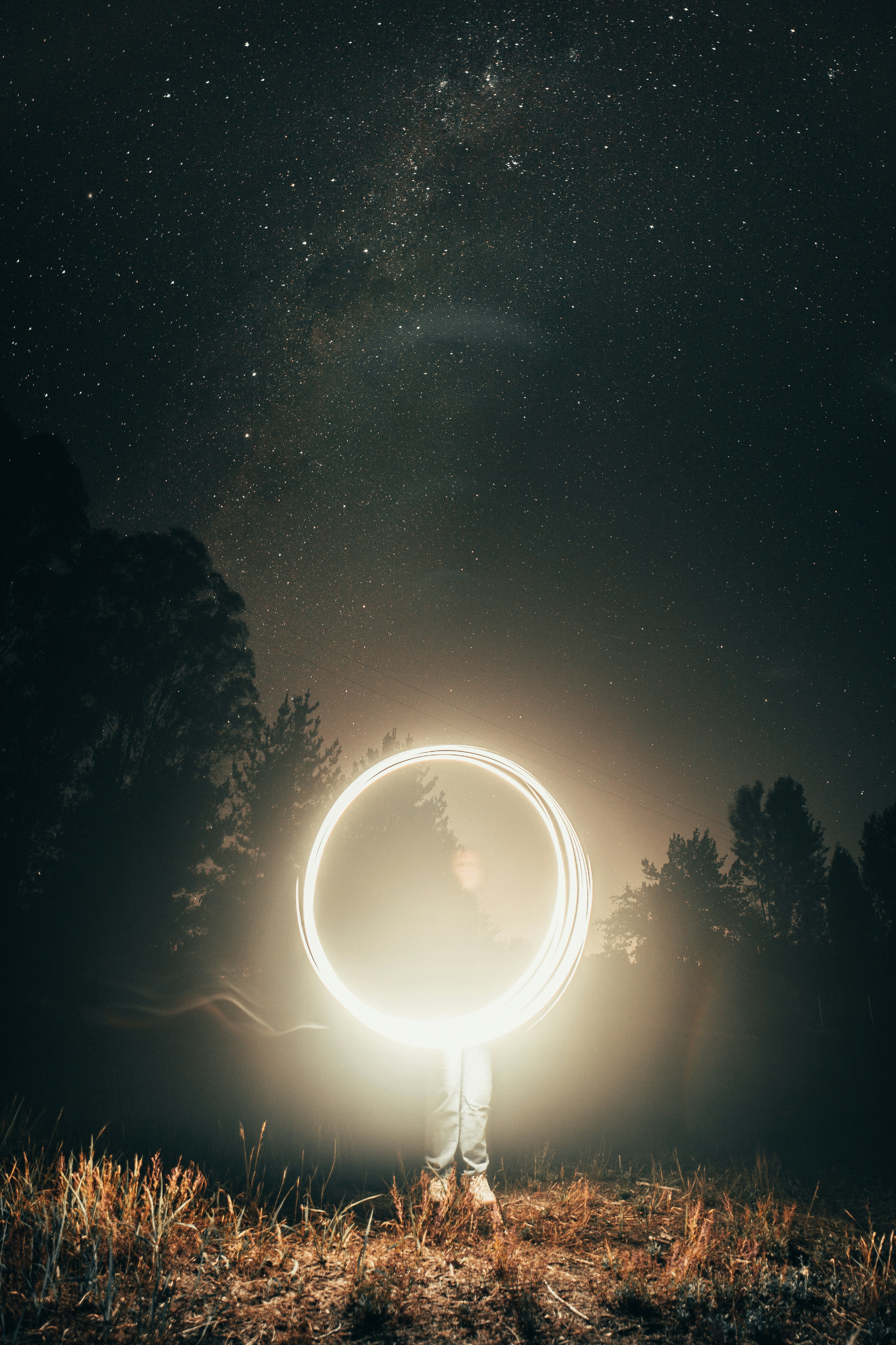 Halo in the Night: A Light-Painted Figure Under a Starry Sky