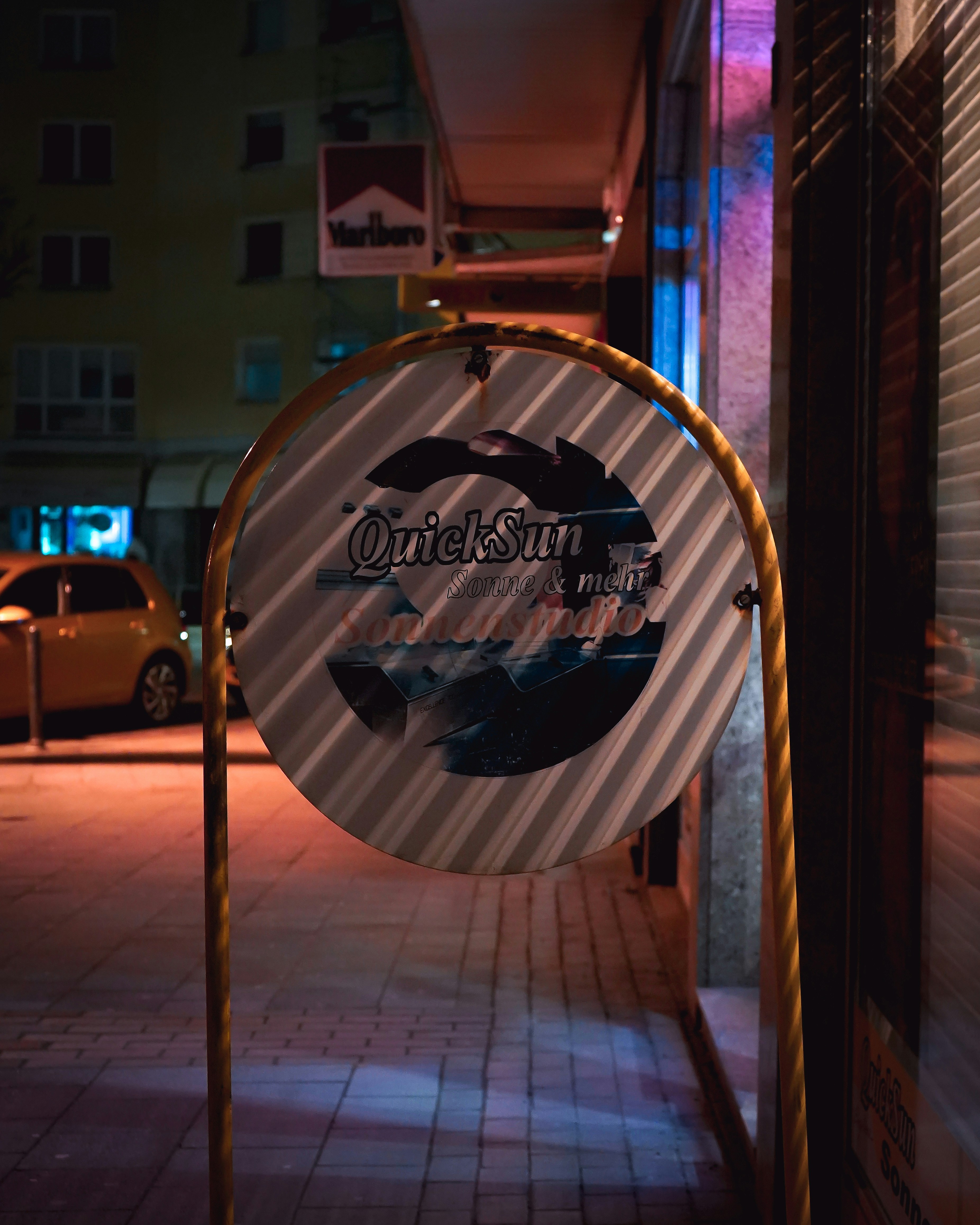 Quicksun Round Sign Bathed in Neon Night