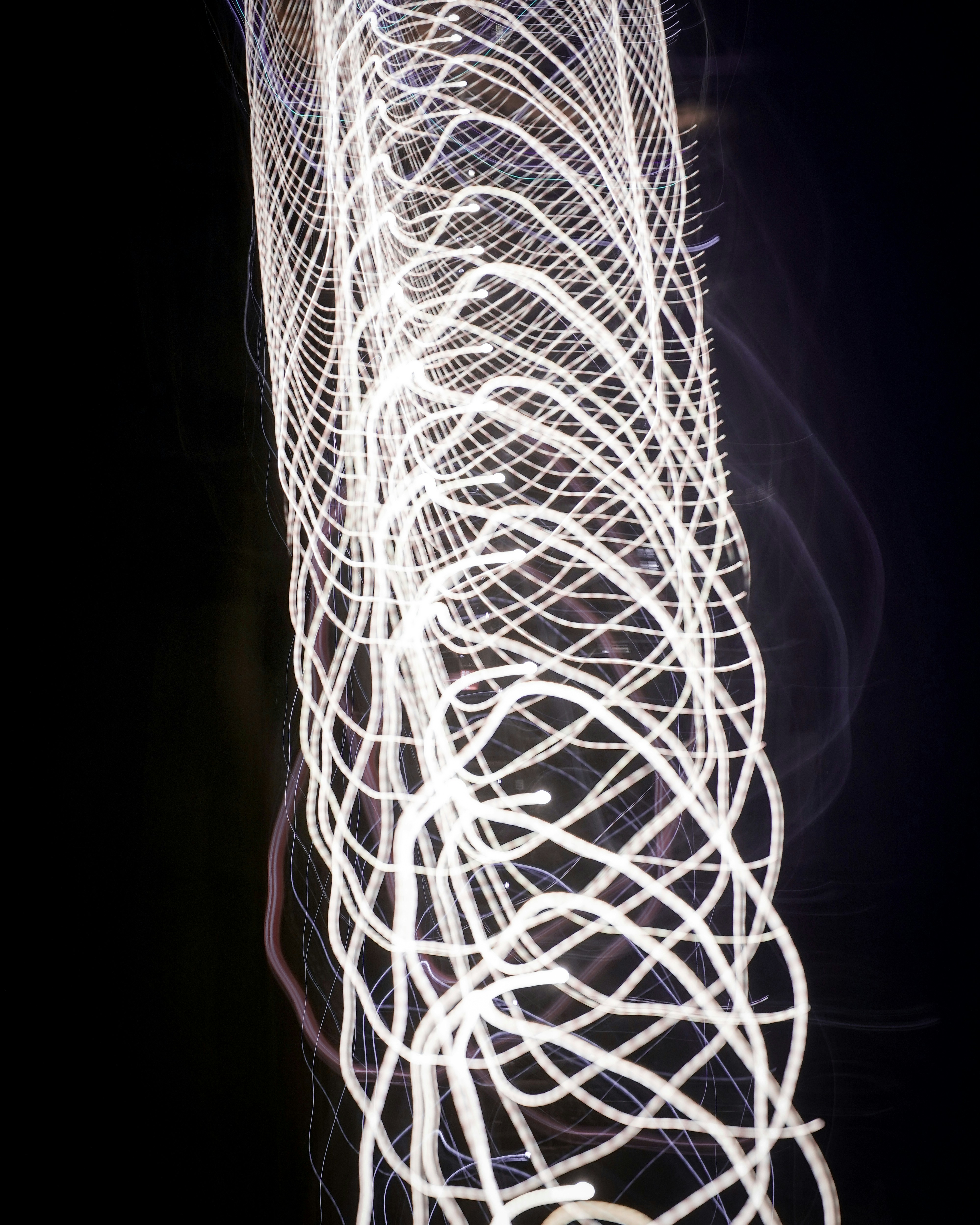Abstract light trails swirling against a dark backdrop, creating a mesmerizing pattern of movement and energy.