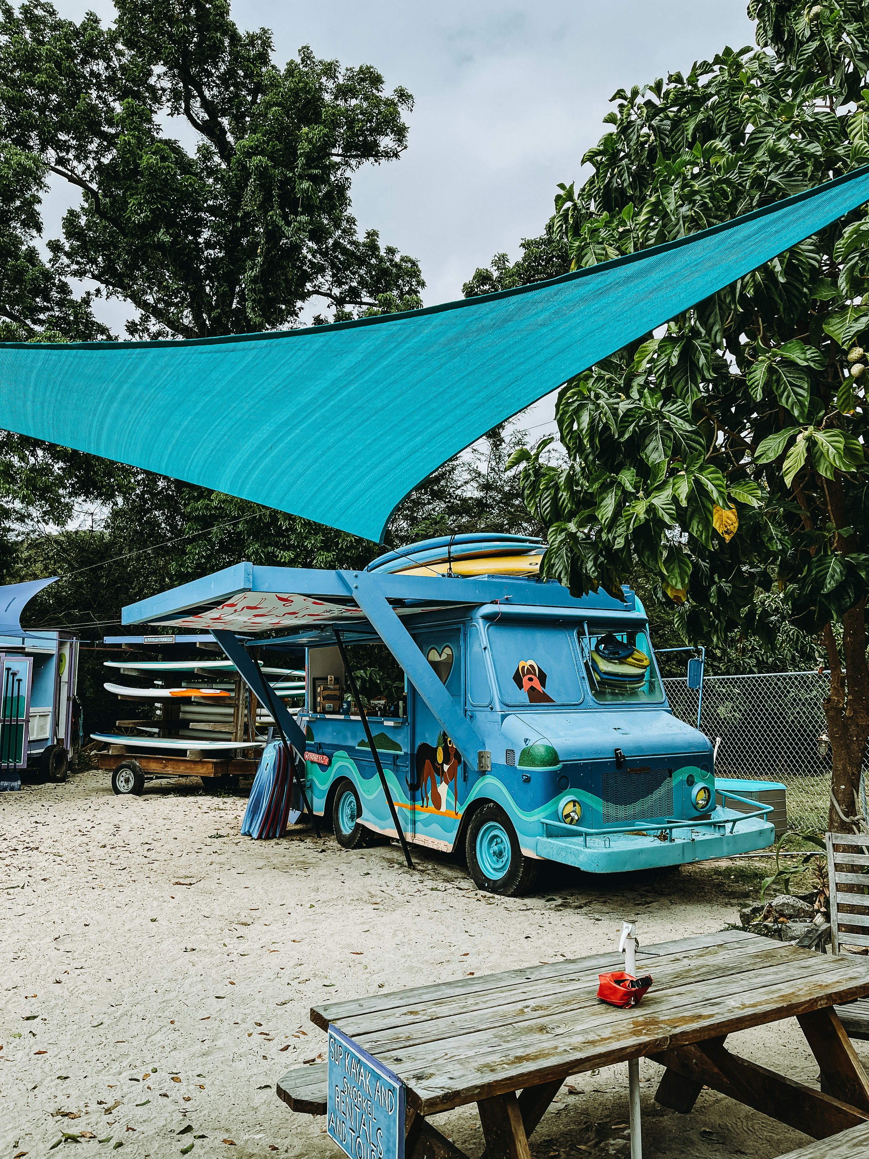 Teal Oasis on Wheels: A Retro Food Truck Under a Blue Shade Sail