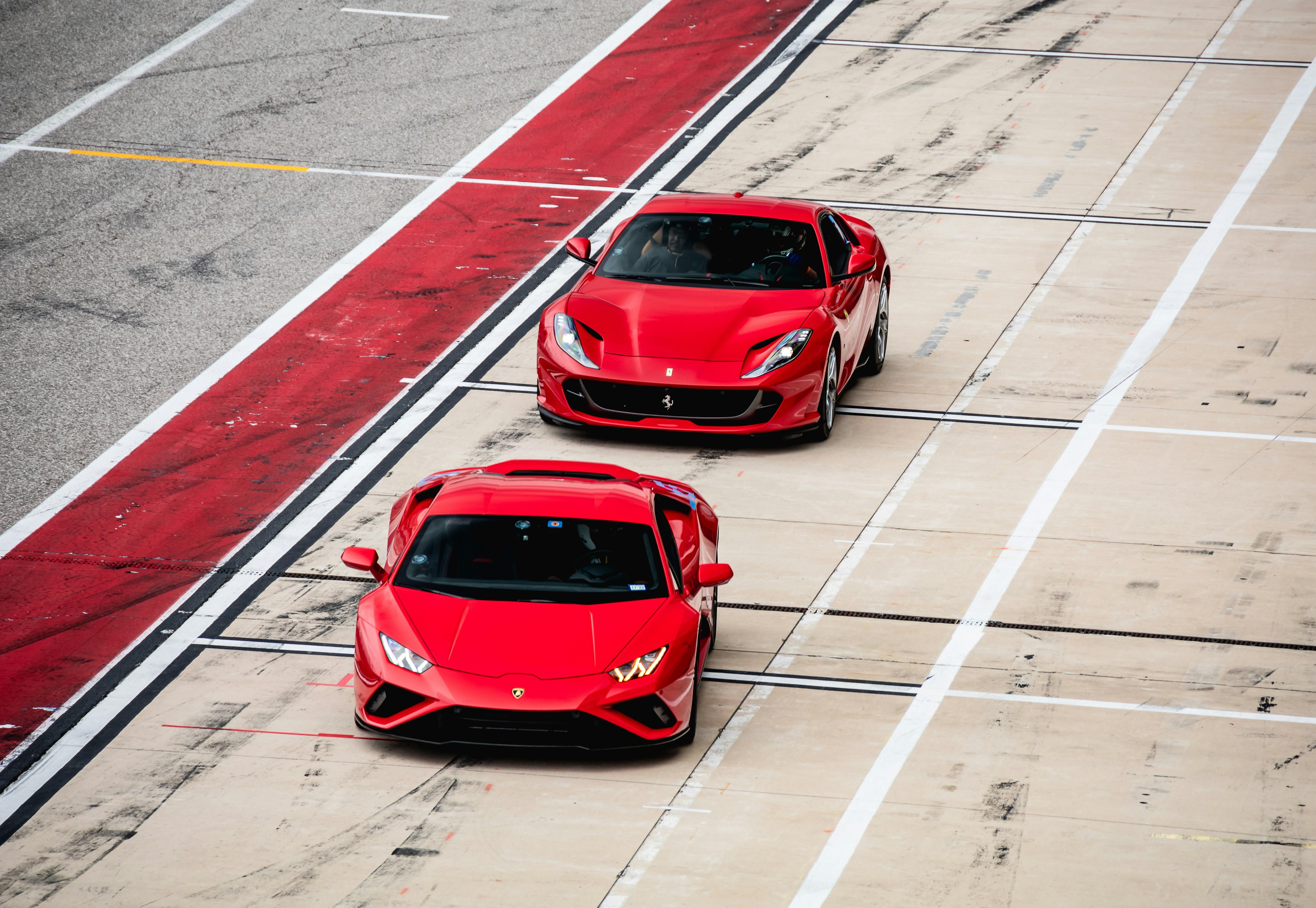 Overhead Sprint: Two Red Ferraris Trace a Painted Runway