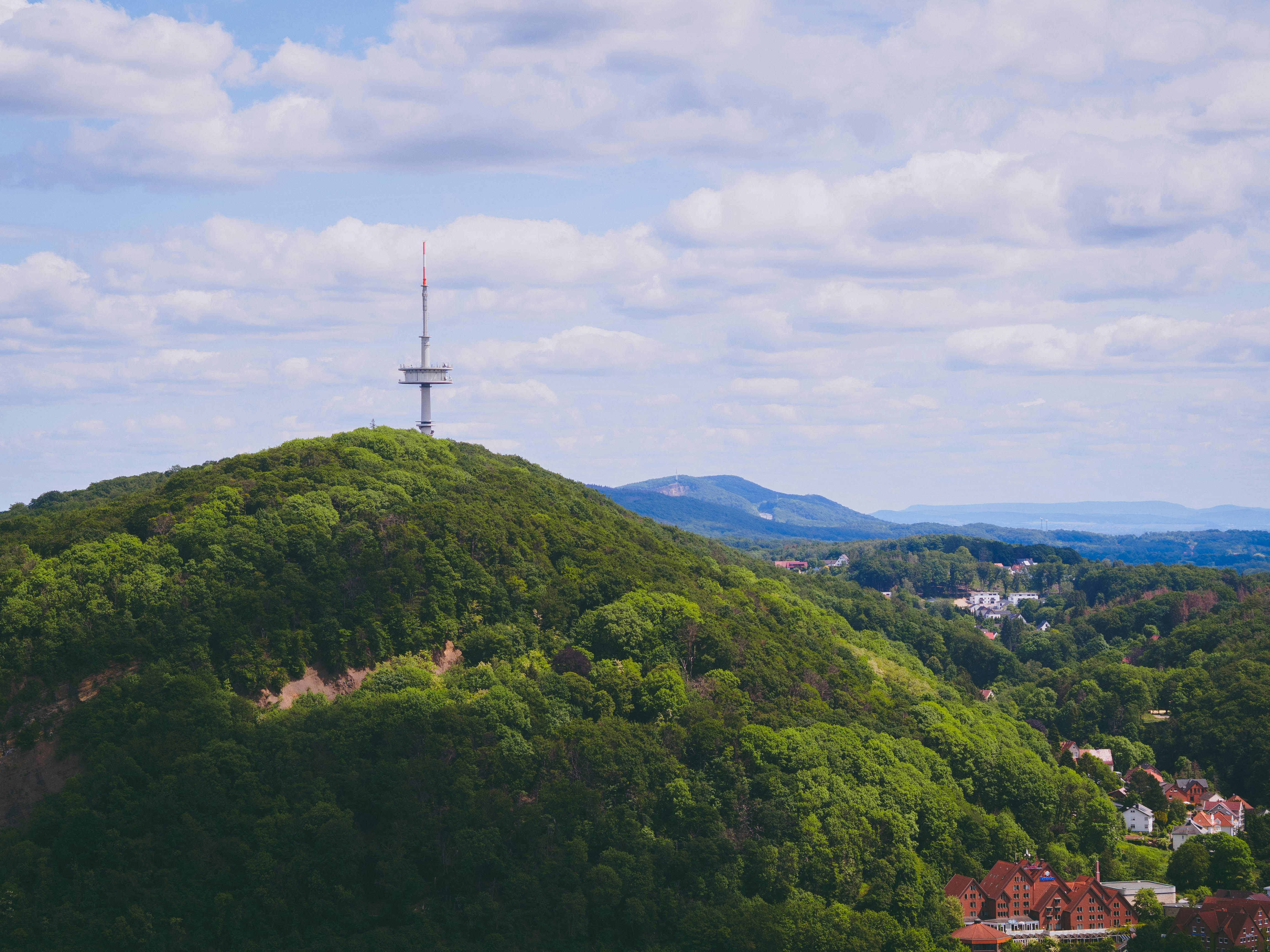 green trees on mountain under white clouds during daytime