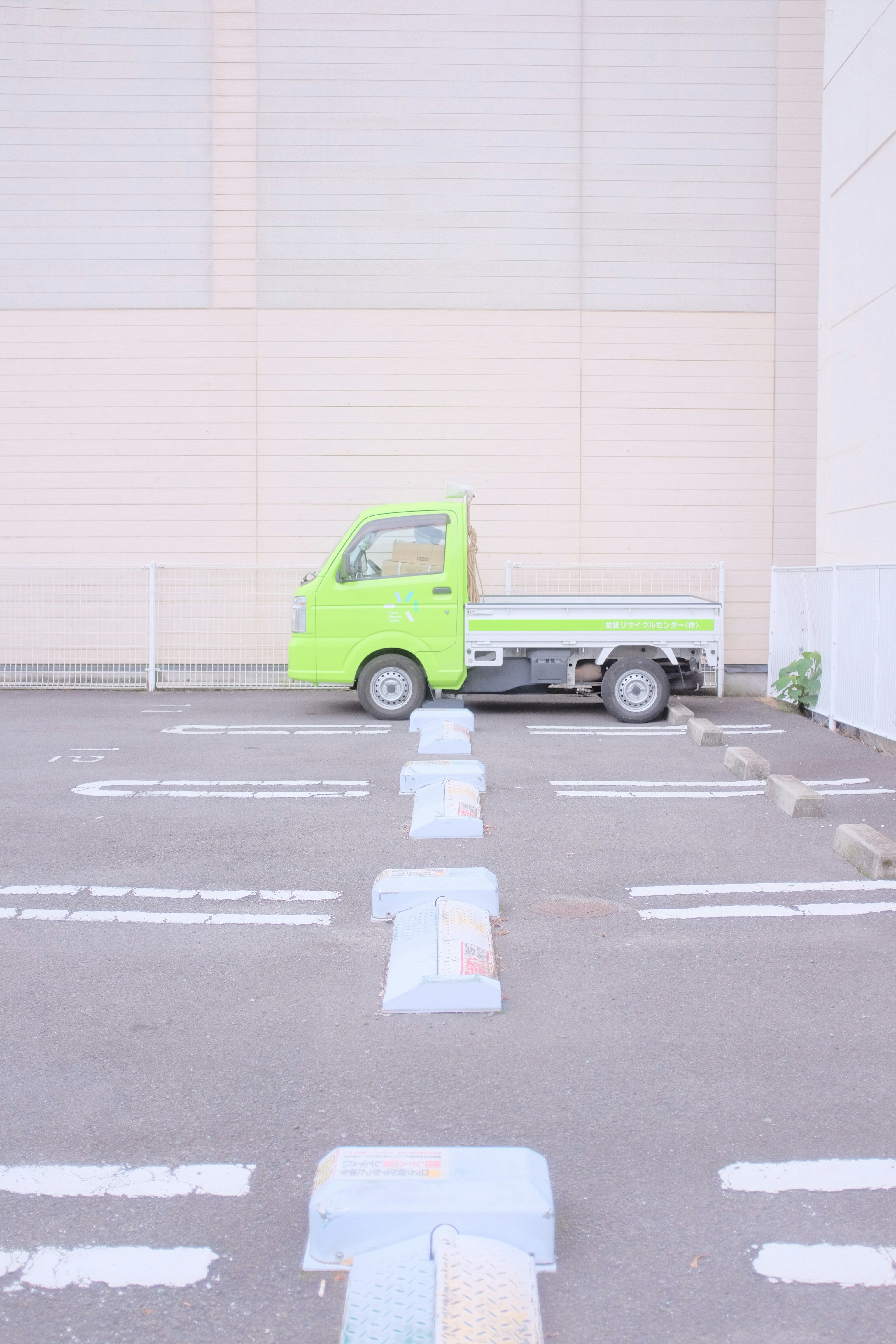 Neon Lime Pickup Pauses Along a Line of Concrete Barriers
