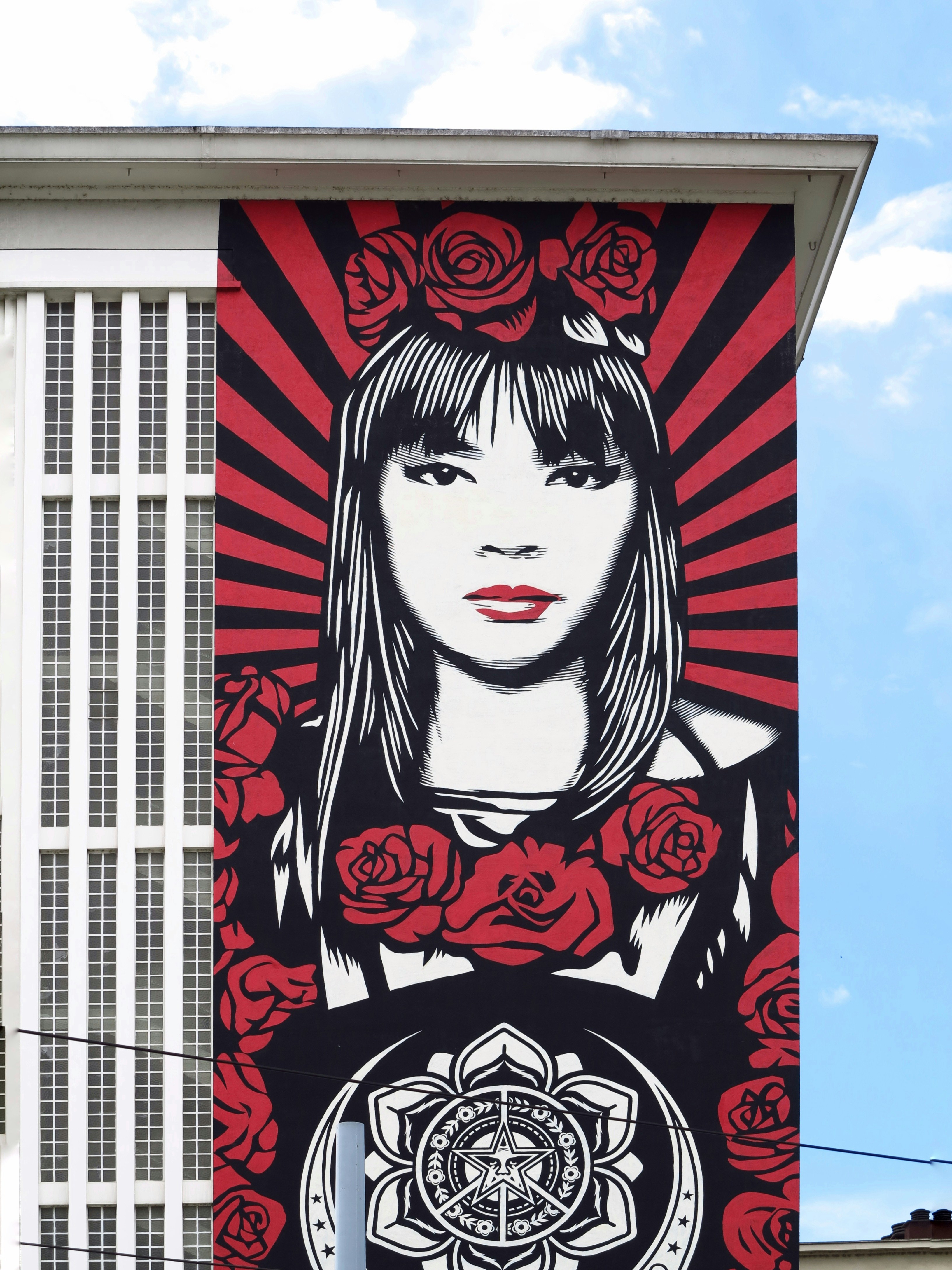 Rising Portrait: Red Roses and Monochrome Muse on a Bright Facade