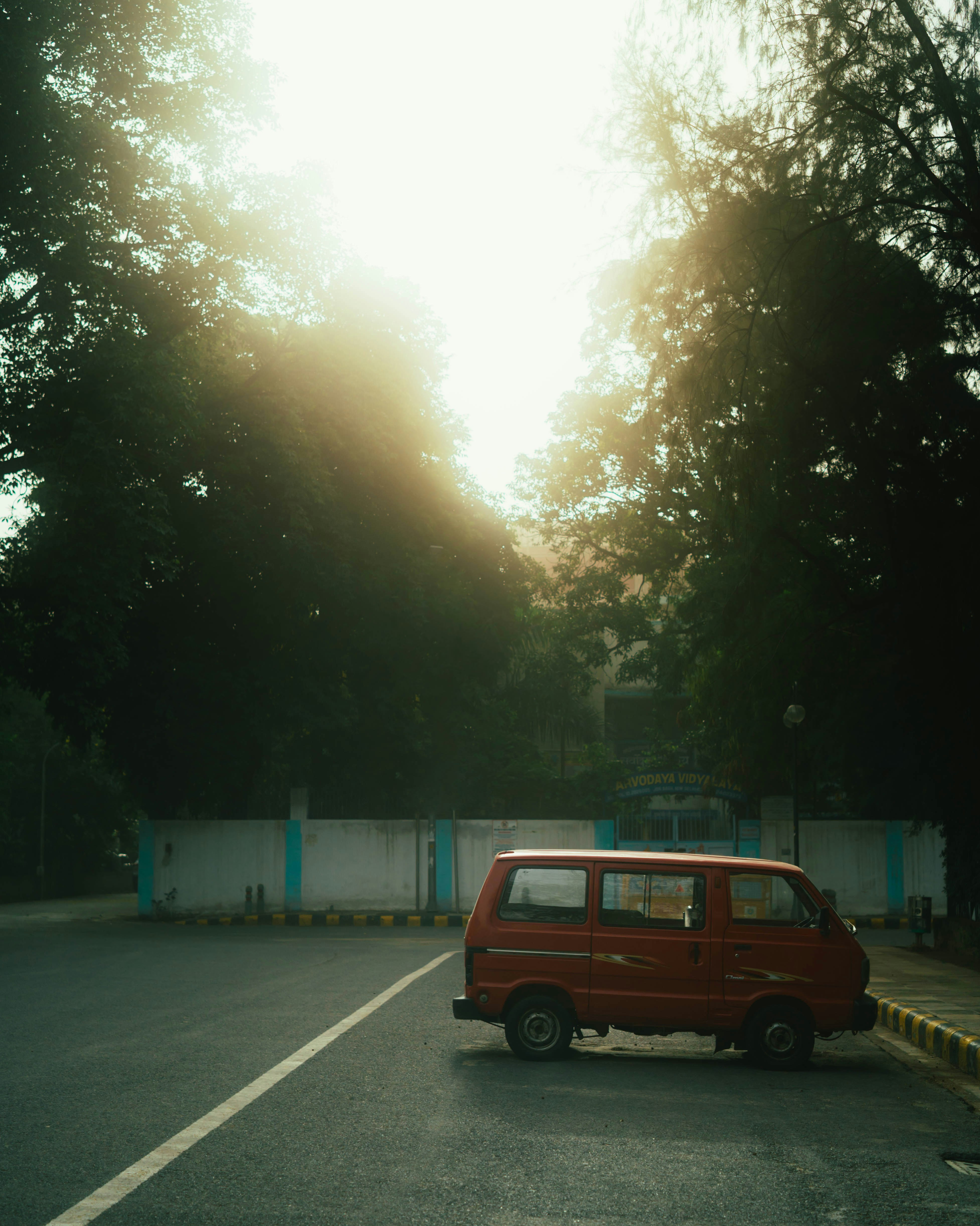 Red Van by the Gate: Sunlit Quiet on a Tree-lined Road