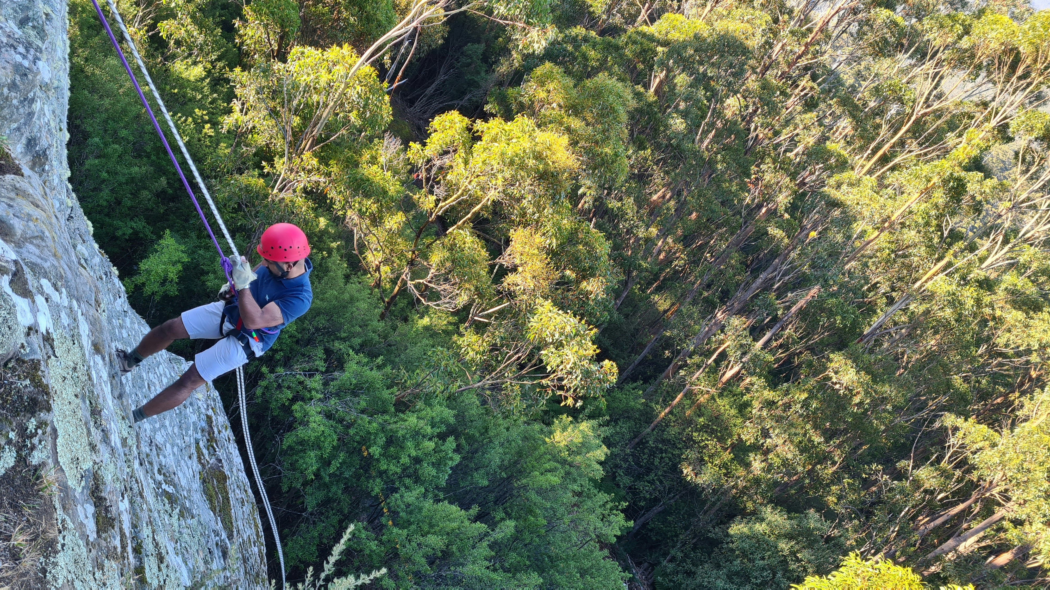 Man in red helmet and black jacket climbing on the mountain photo ...