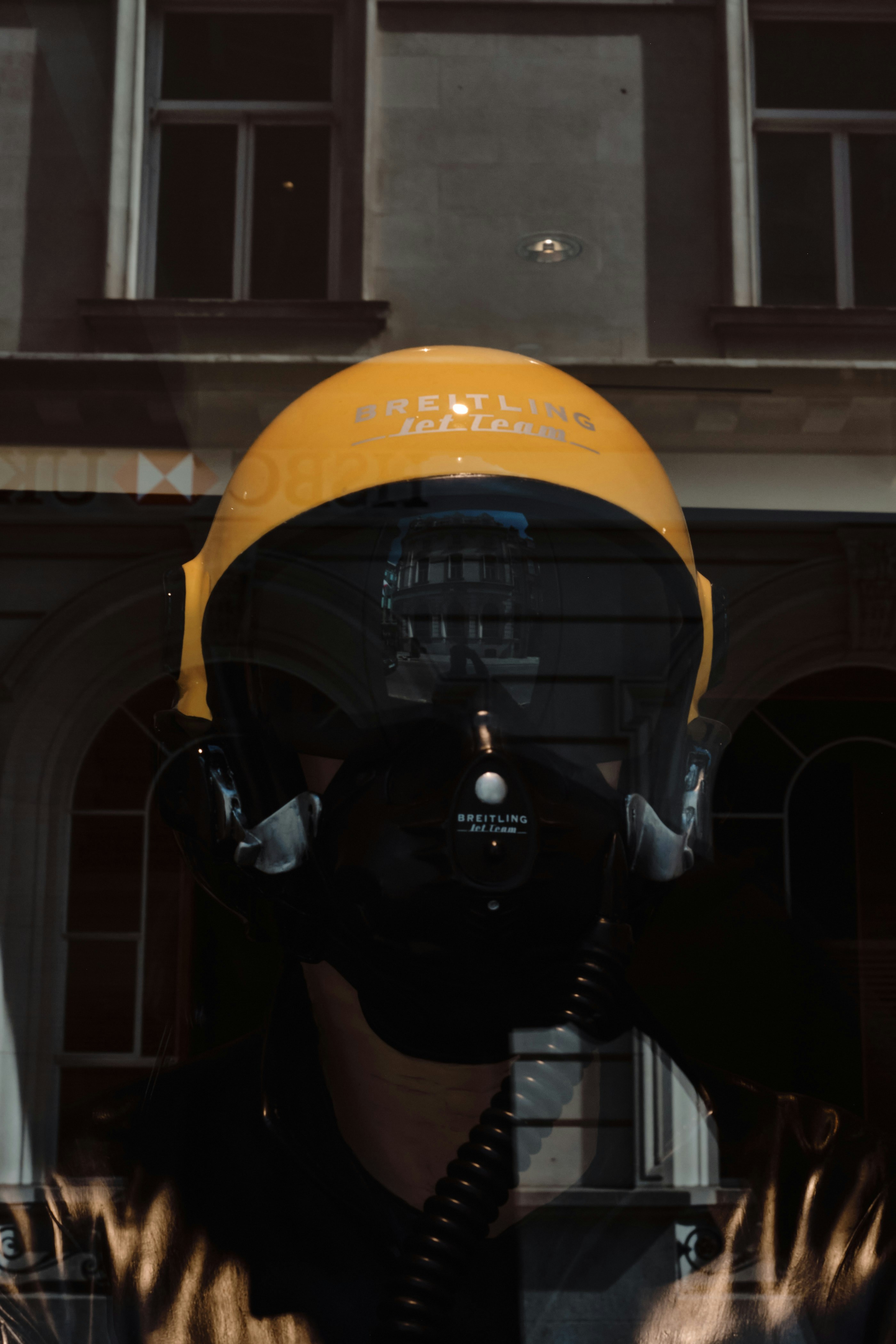 The Neon Breitling Helmet: City Reflections in a Shopfront Window