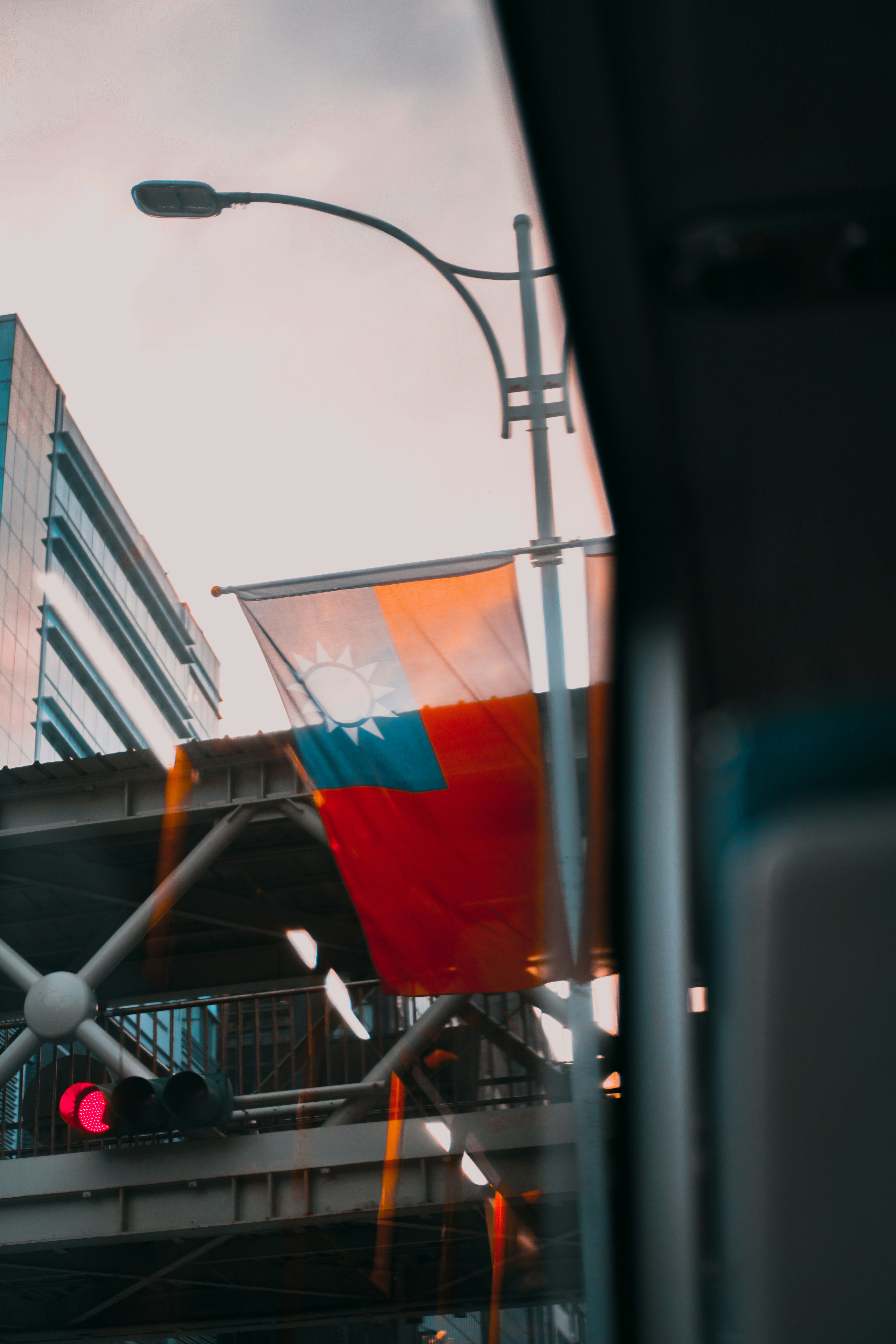 Taiwan Flag Draped Over an Urban Overpass, Framed by Steel and Streetlight