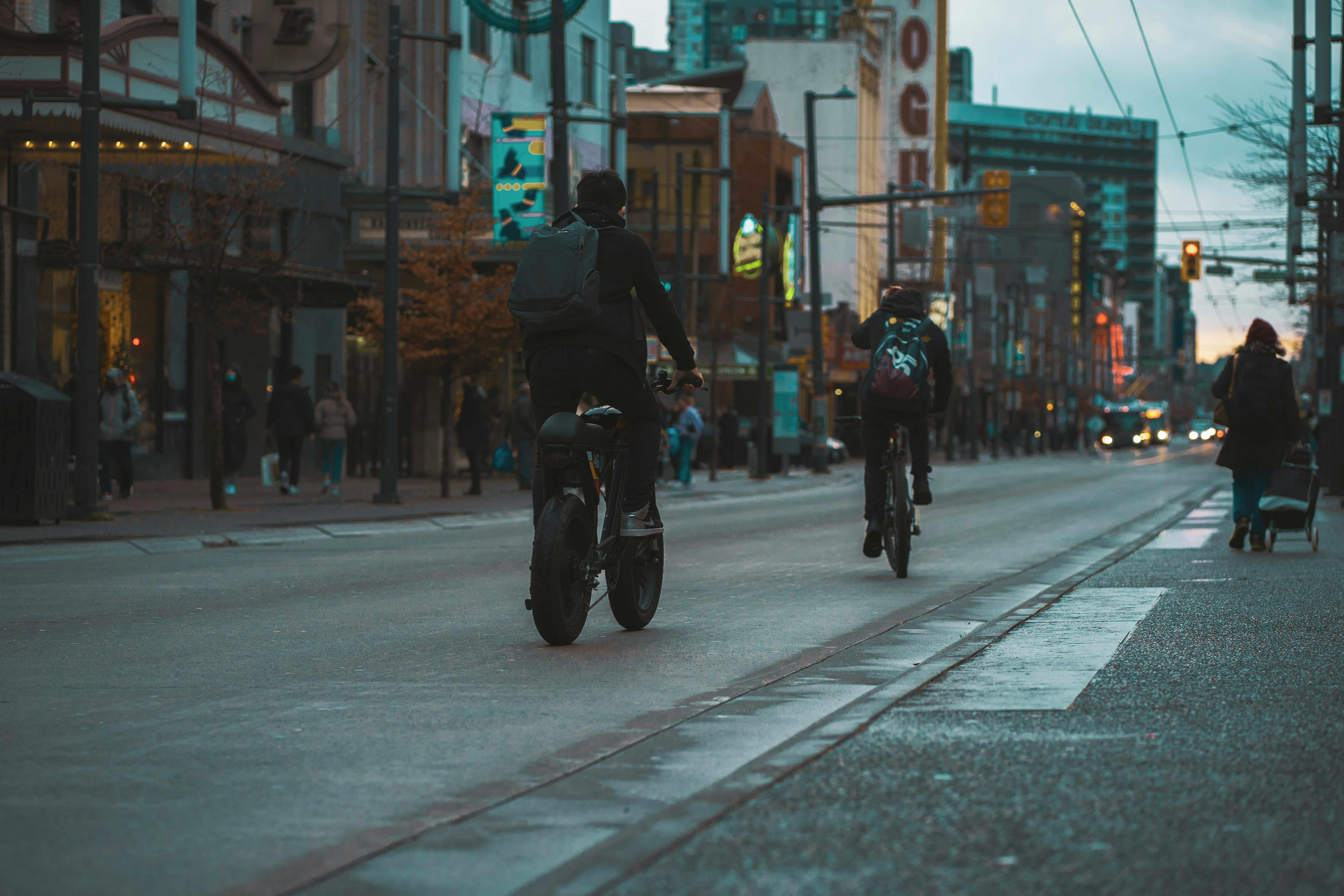 Man in black jacket and black pants riding bicycle on road during ...