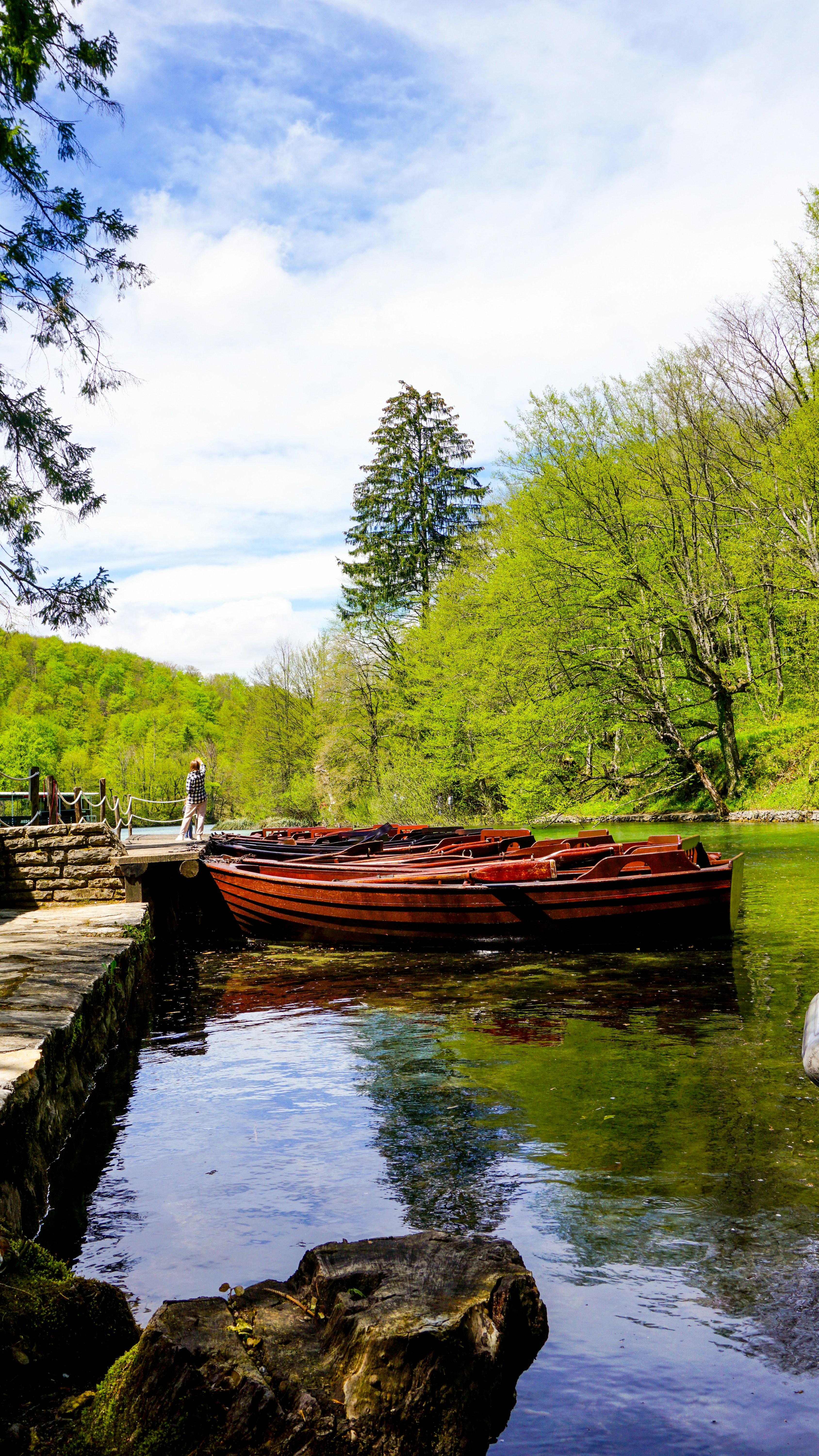 Rowboats Rest Along a Quiet Riverside in Spring